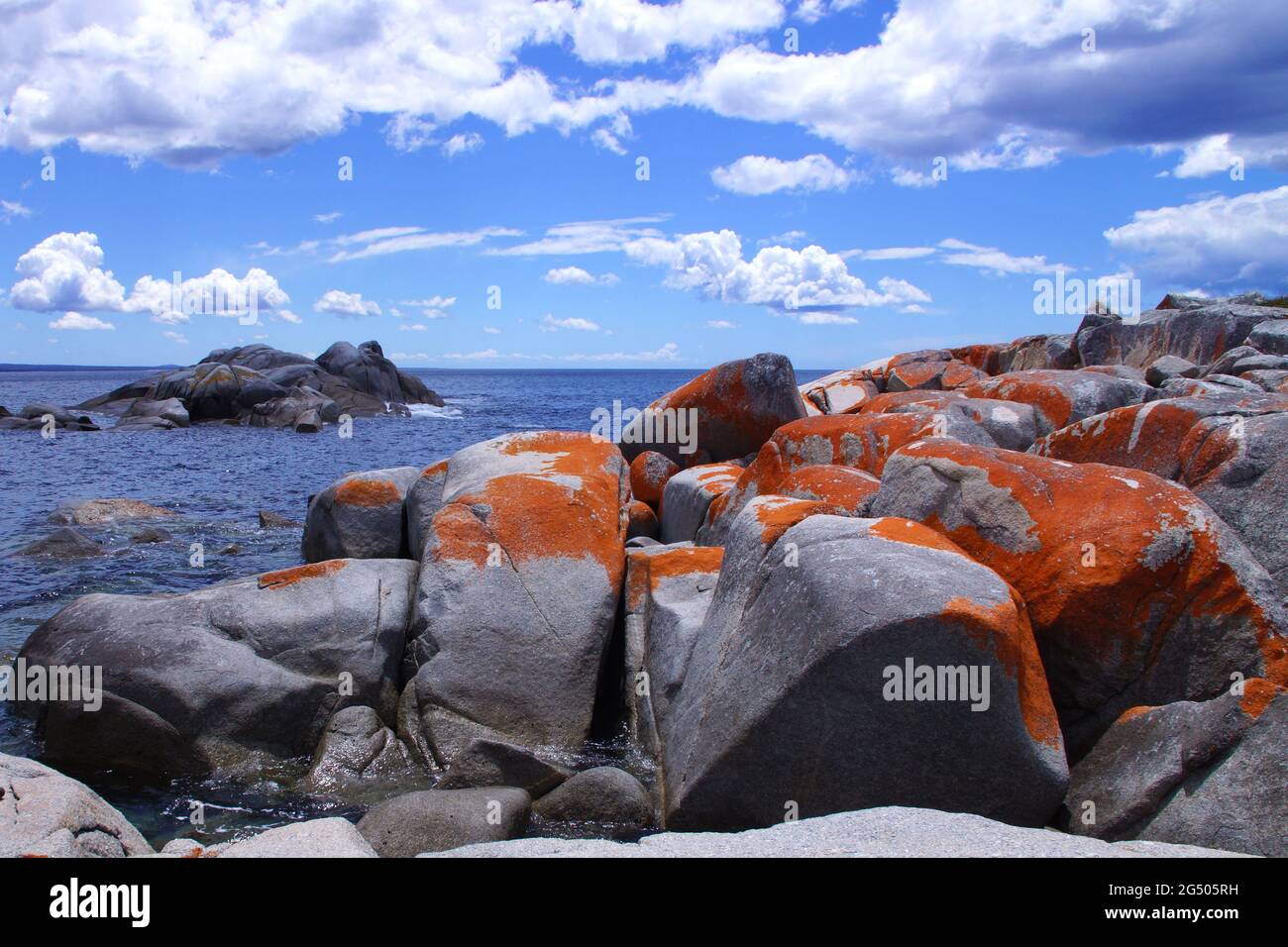 Red rocks and blue sea at the Bay of Fires, Tasmania Stock Photo - Alamy