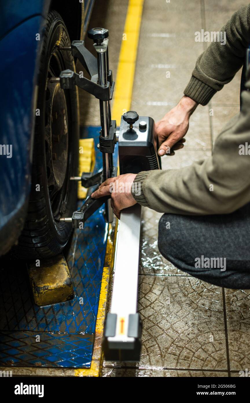 Close-up of a tire clamped by a leveler that passes the automatic ...