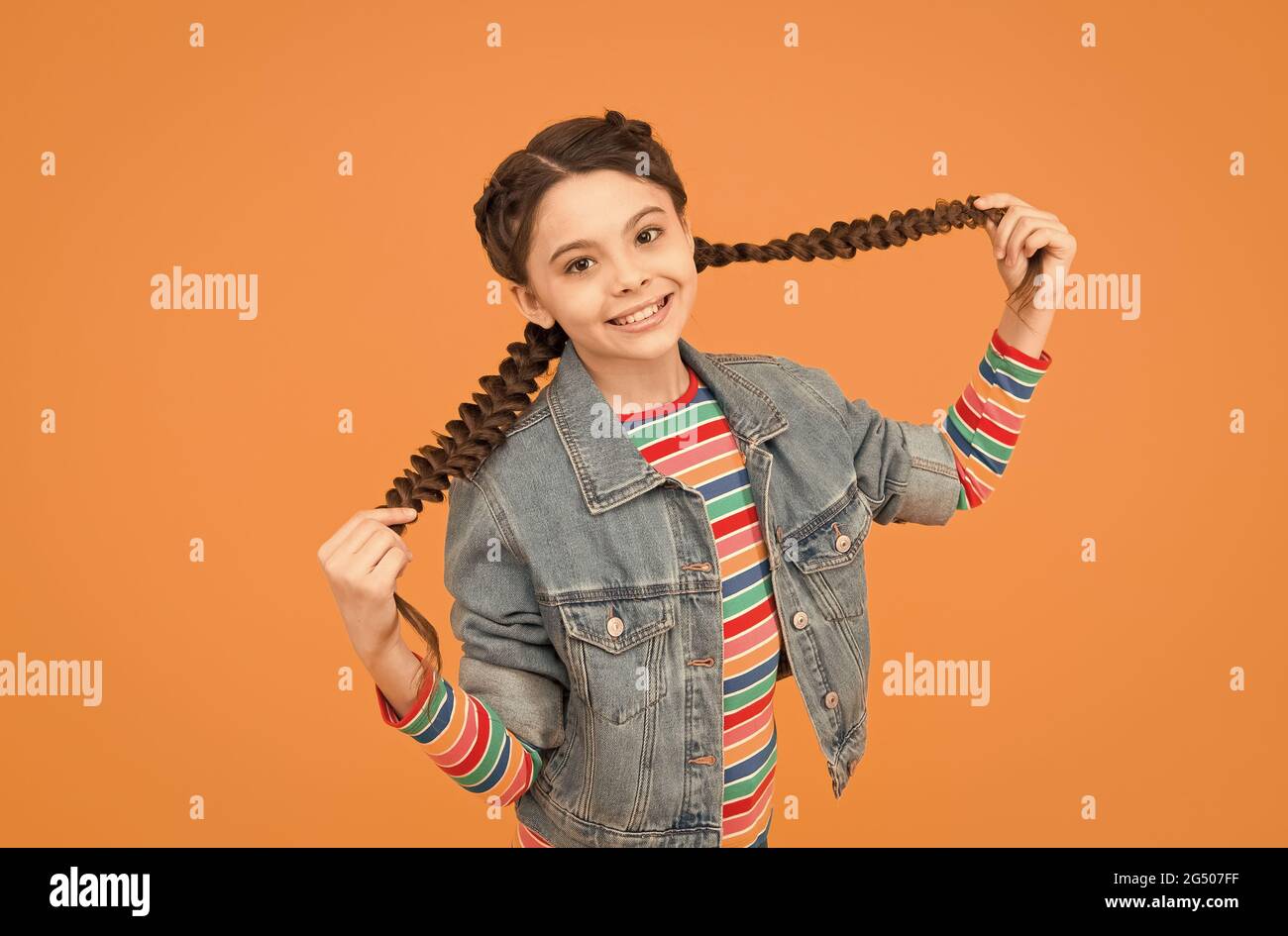 Happy little girl with braids wear denim clothes, modern style concept ...