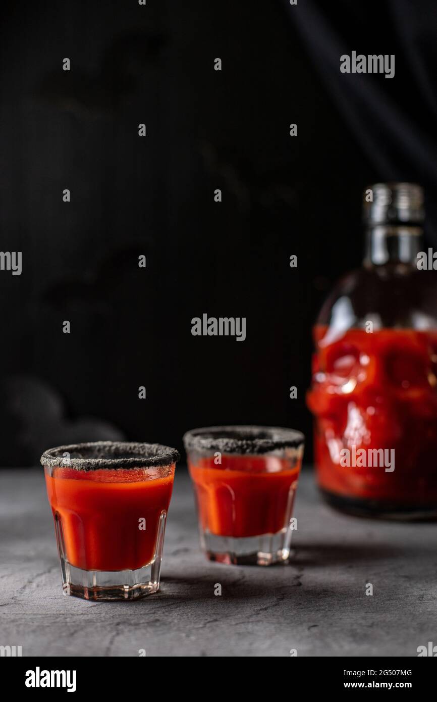 Tomato cocktail in a skull-shaped bottle and glasses. Drink for ...