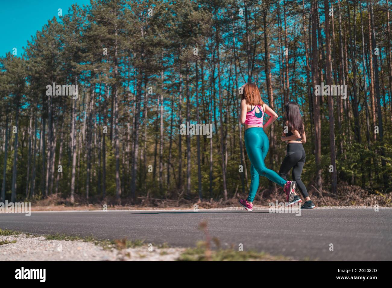 Side view of Two pretty girls jogging in the morning outdoors Stock ...