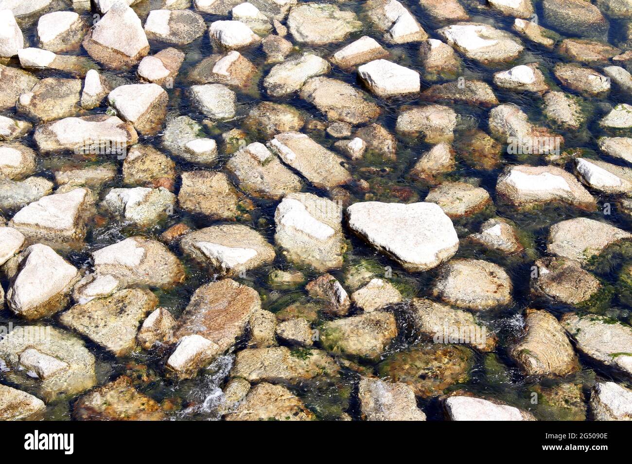 Pebbles submerged in water - Aerial view of stones in empty clear fresh ...