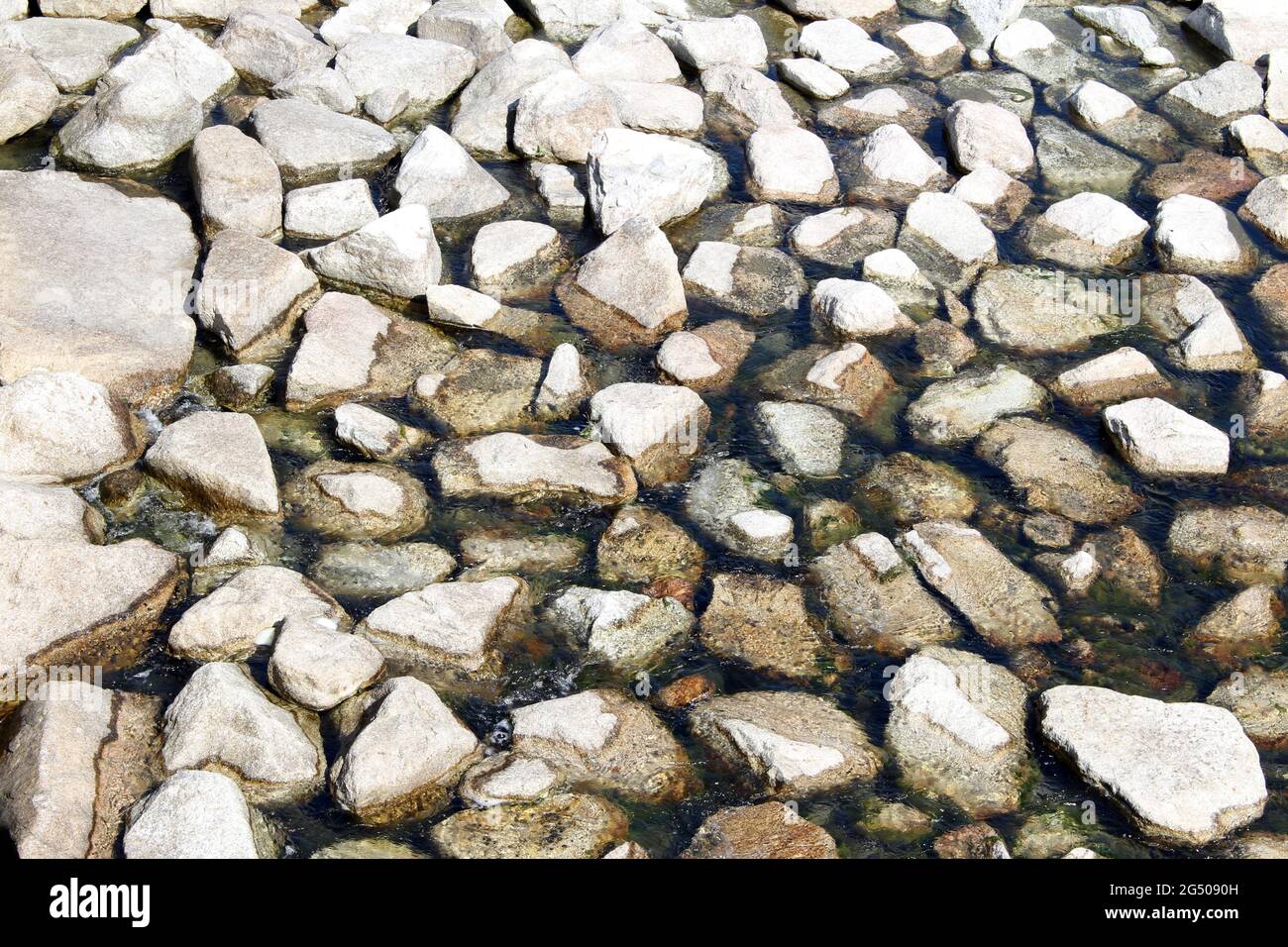 Pebbles submerged in water - Aerial view of stones in empty clear fresh ...