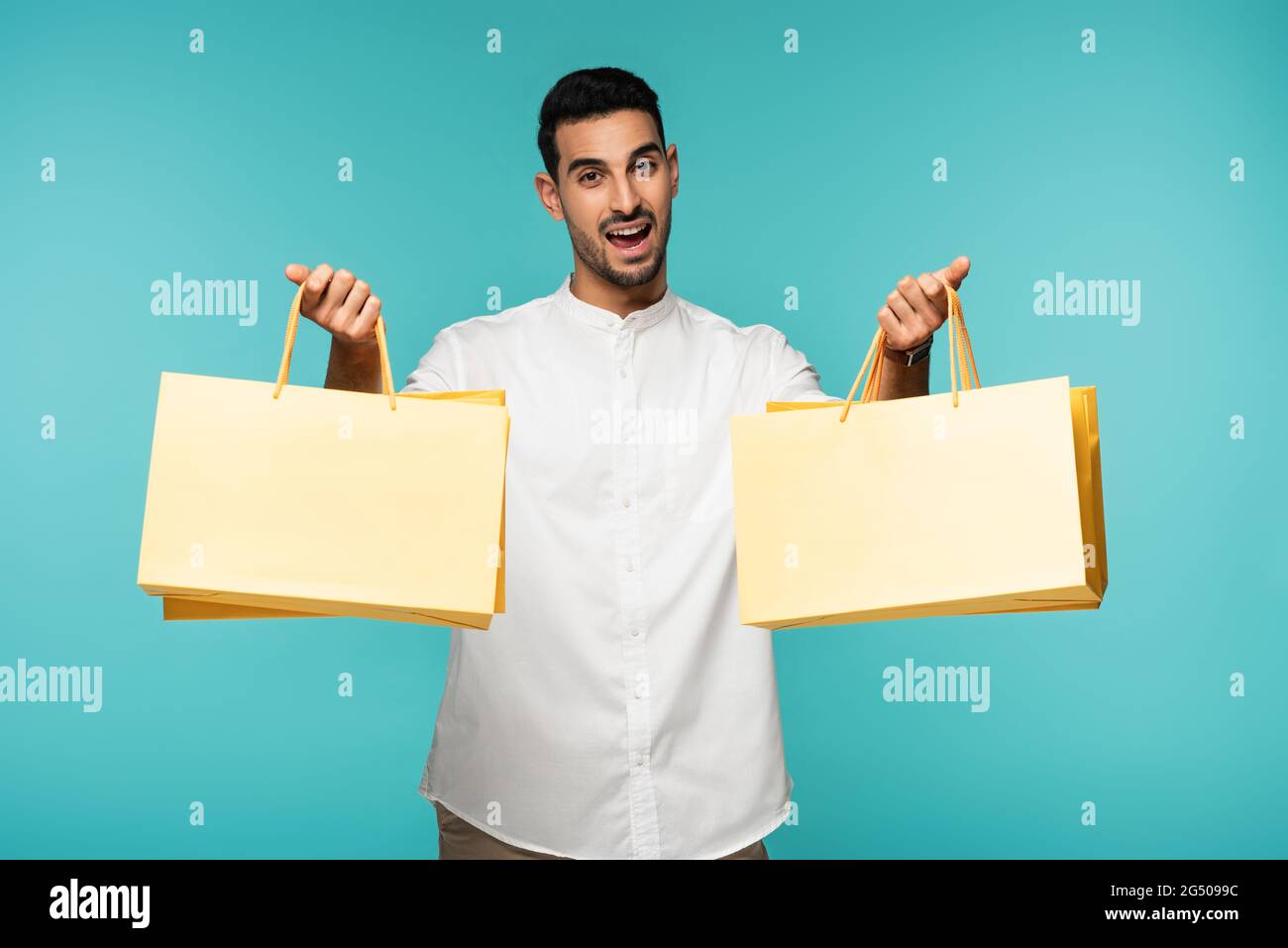Happy muslim customer holding shopping bags isolated on blue Stock ...