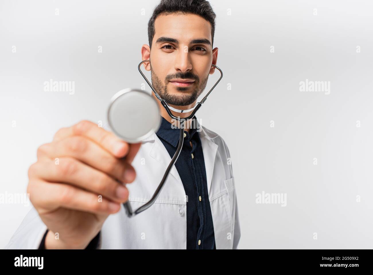 Arabian doctor holding blurred stethoscope and looking at camera ...
