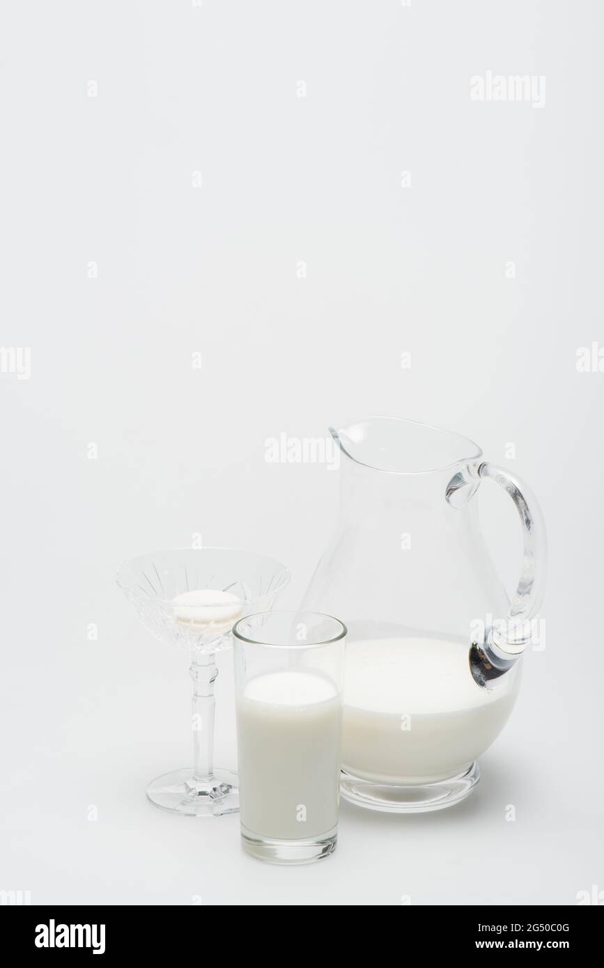 macaron in dessert dish near glass of milk and jug on white Stock Photo ...
