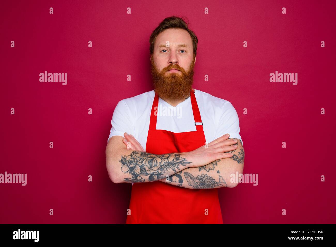serious isolated chef with beard and red apron Stock Photo - Alamy