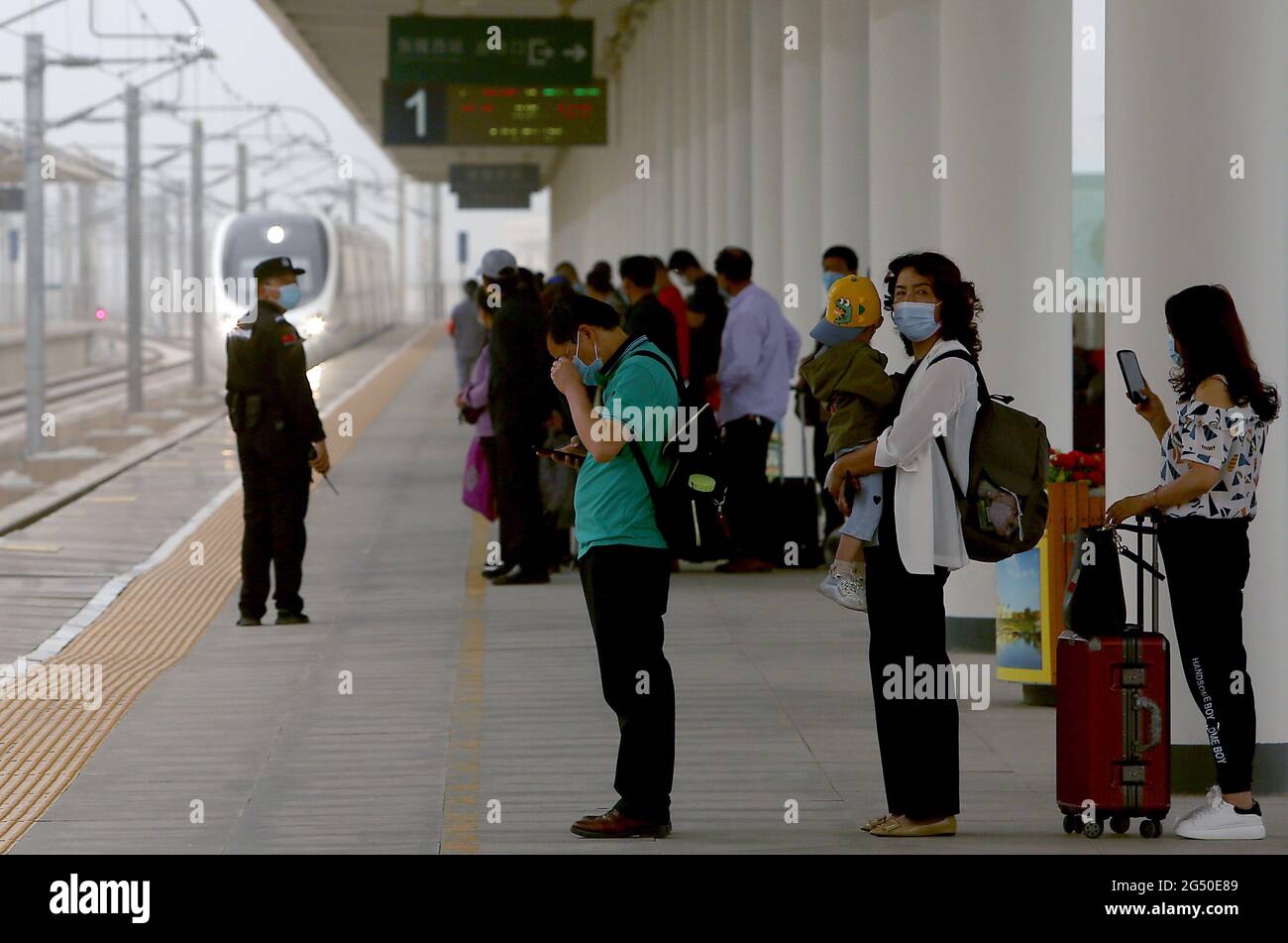 Chinese travelers wait for a high-speed train to arrive at Tianshui's ...