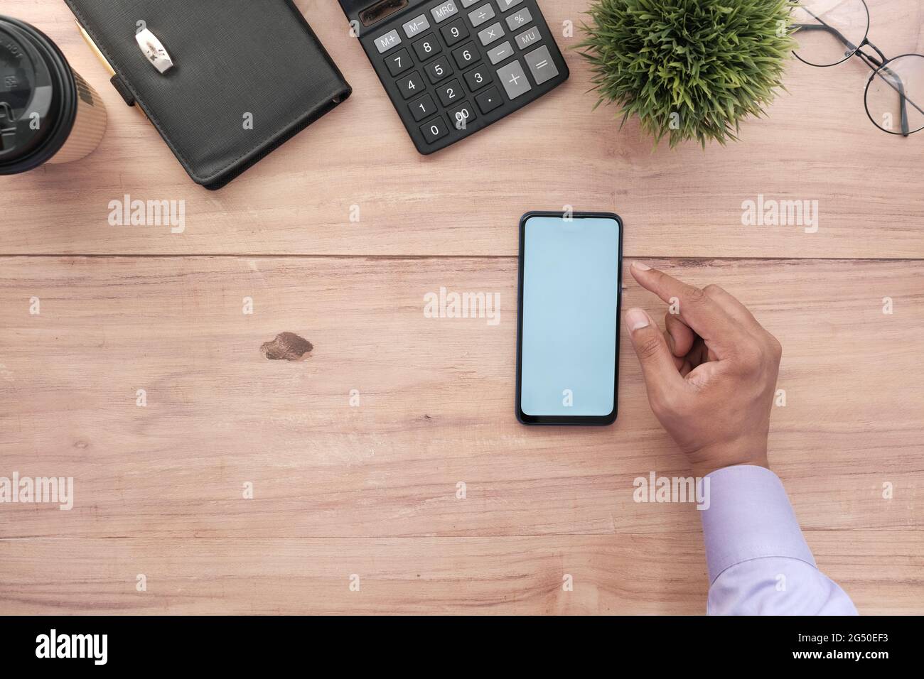 top view of man hand using smart phone on office desk Stock Photo - Alamy