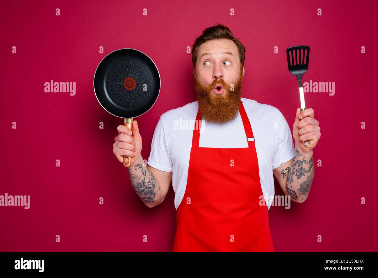 surprised chef with beard and red apron is ready to cook Stock Photo ...