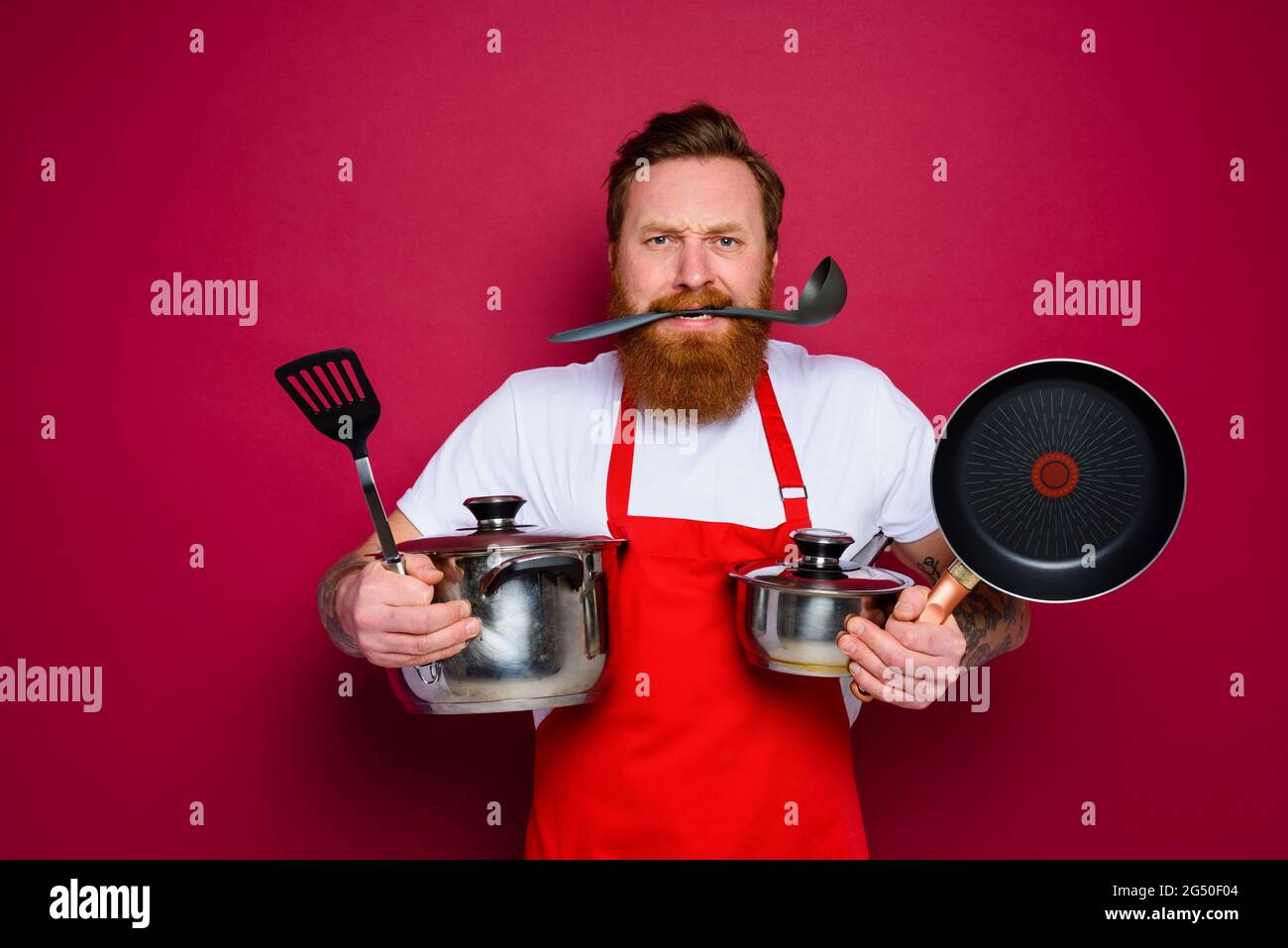 aggressive chef with beard and red apron is ready to cook Stock Photo ...