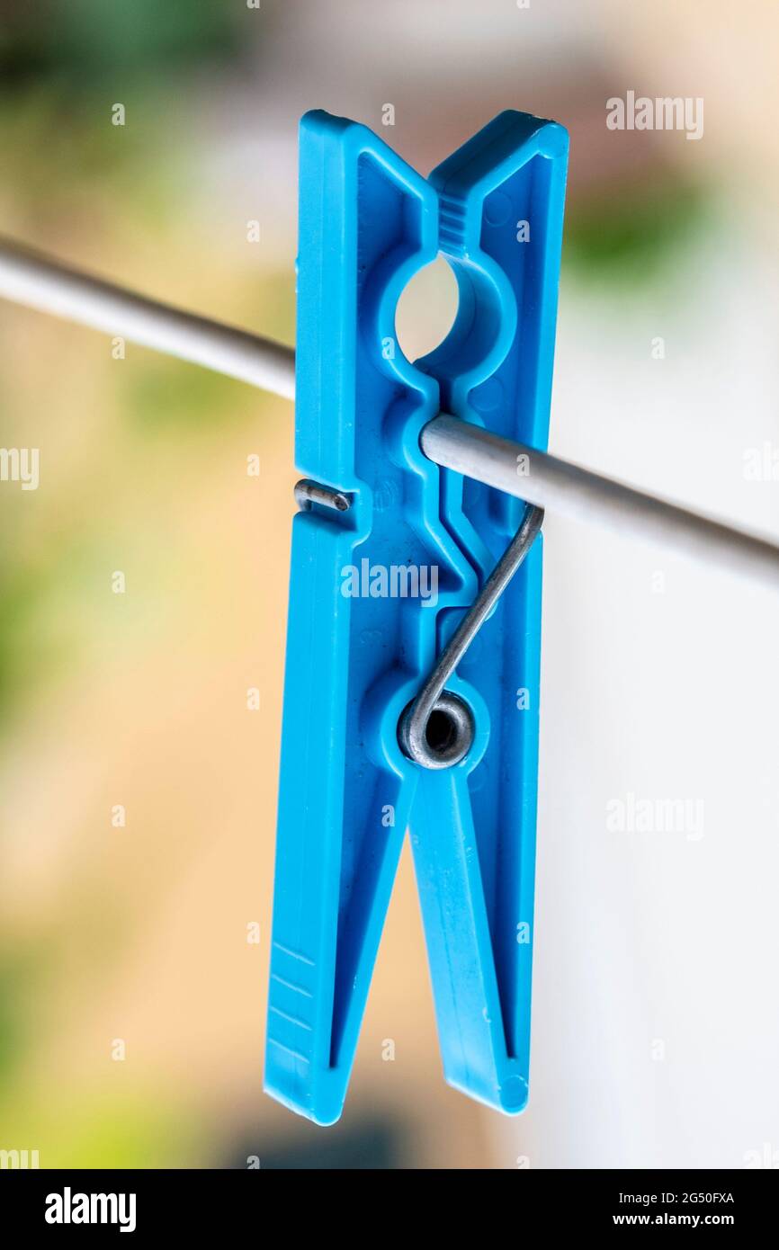 Colored clothes peg hanging by a thread Stock Photo - Alamy