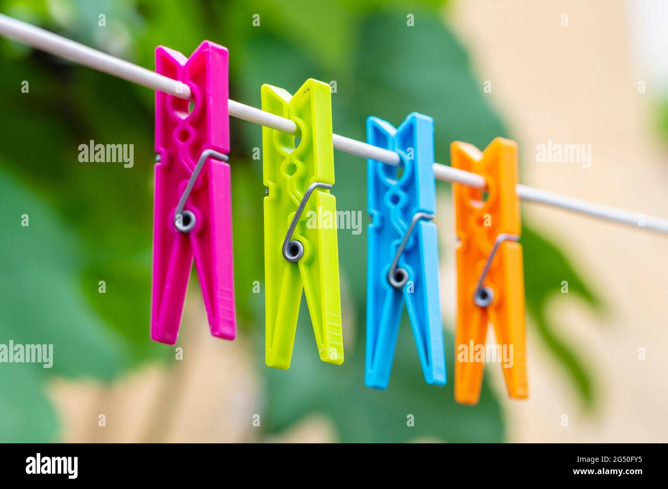 Colored clothespins hanging by a thread Stock Photo - Alamy