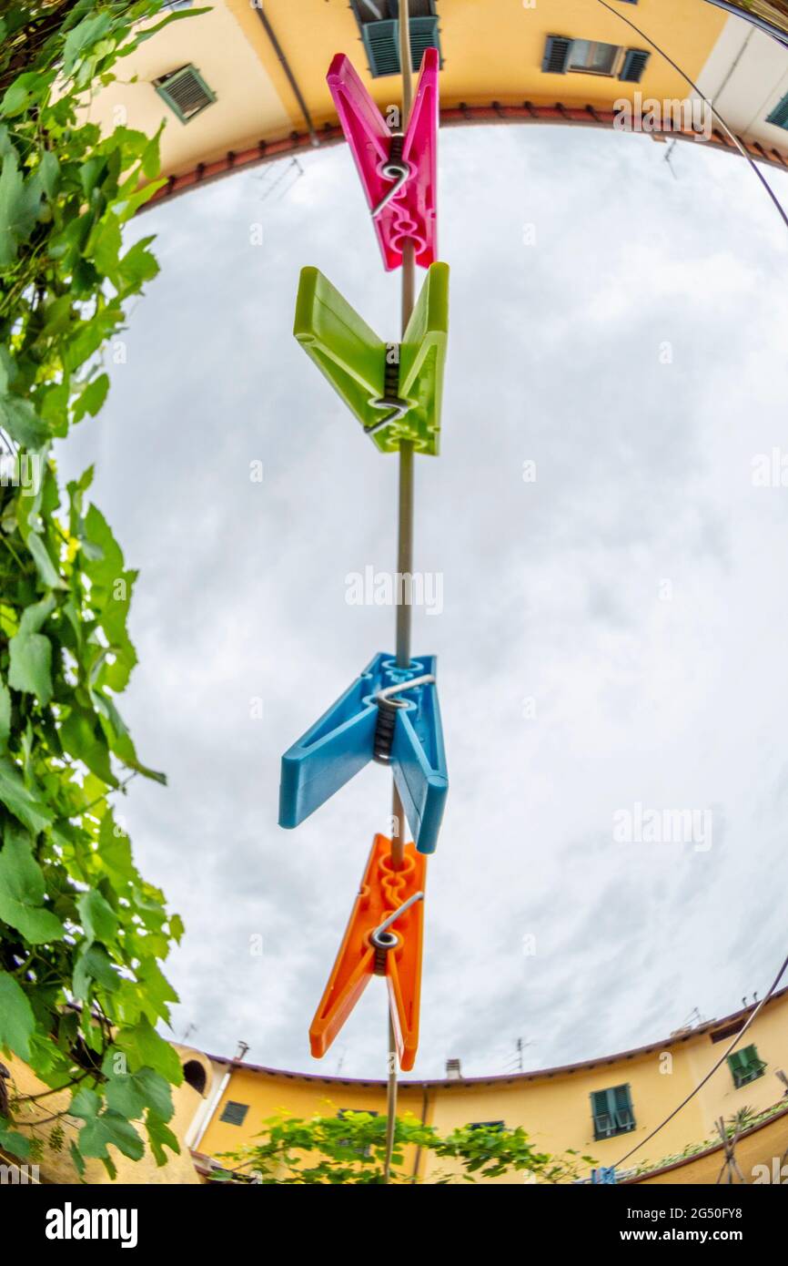 Colored clothespins hanging by a thread Stock Photo - Alamy