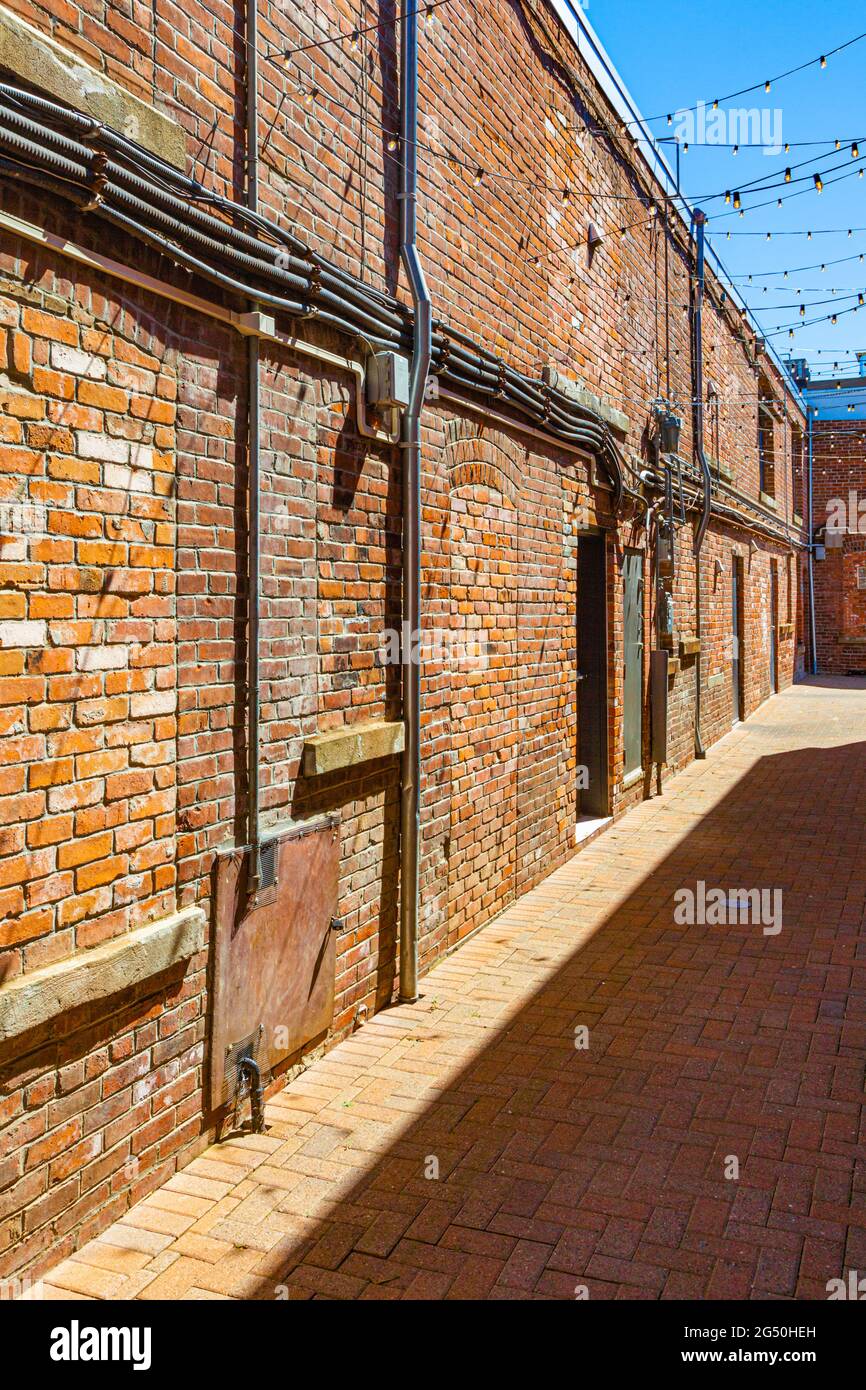 Narrow back alley between red brick buildings in downtown Victoria ...