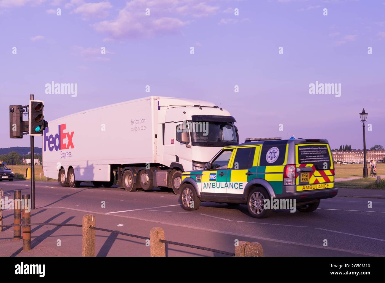 FedEx delivery lorry met London Ambulance at Traffic lights on sunny ...