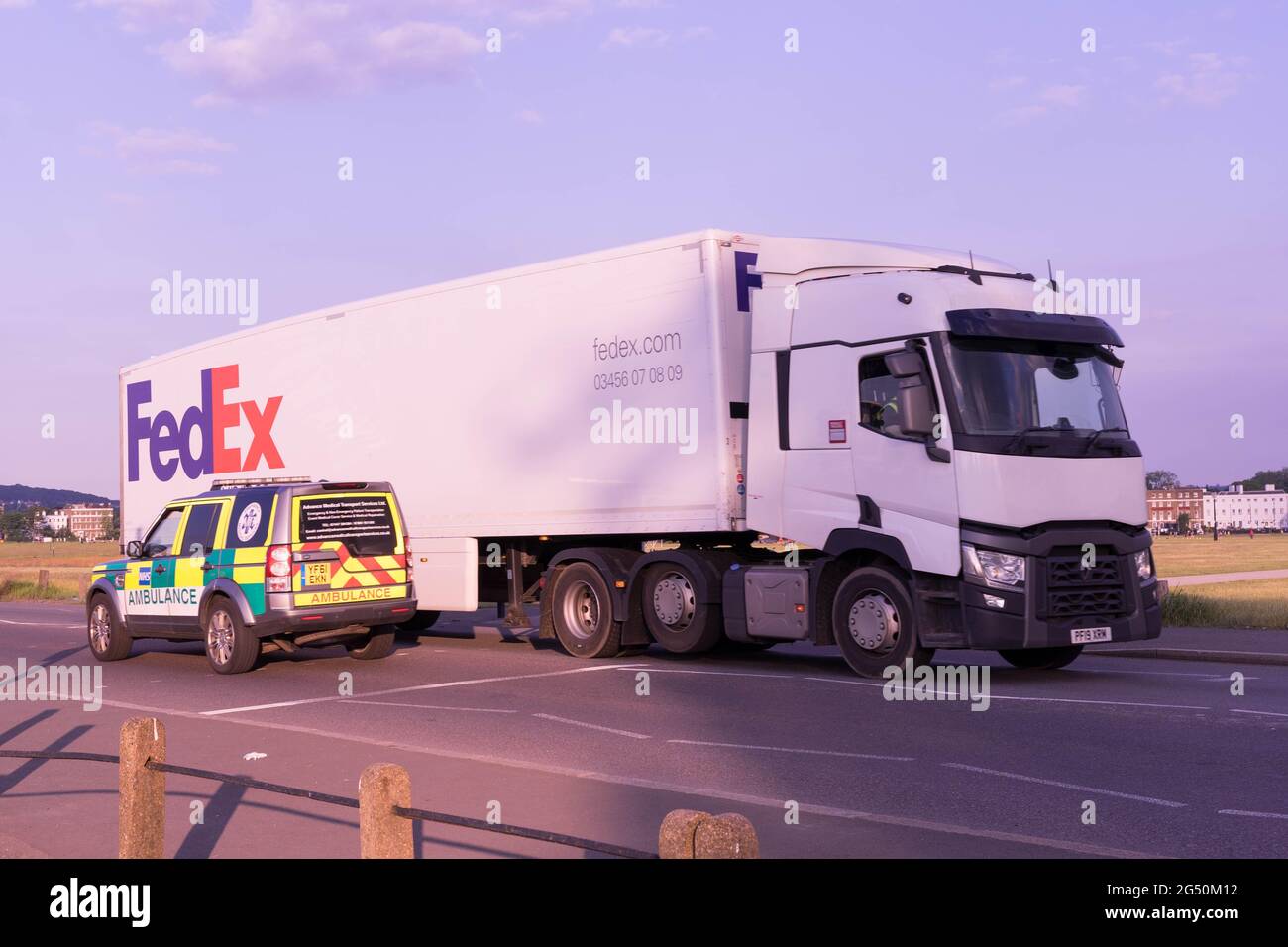 FedEx delivery lorry met London Ambulance at Traffic lights on sunny ...