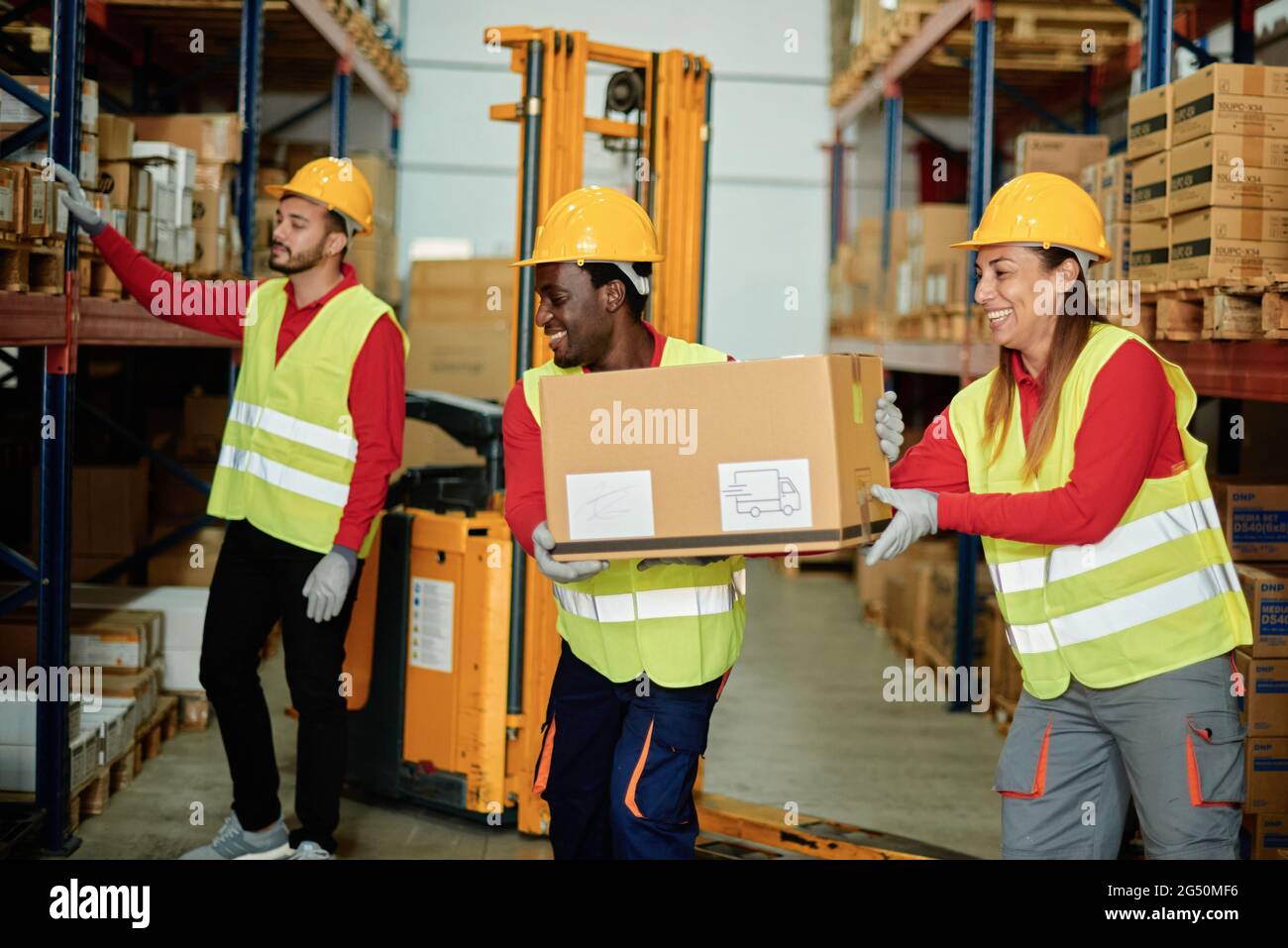 Positive diverse workers unloading boxes in warehouse Stock Photo - Alamy