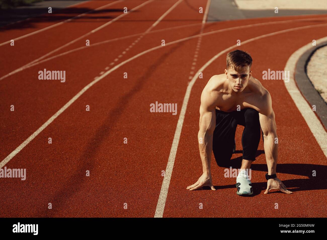 young guy with athletic body getting ready to run Stock Photo - Alamy