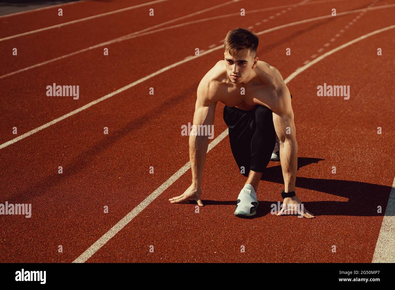 young guy with athletic body getting ready to run Stock Photo - Alamy