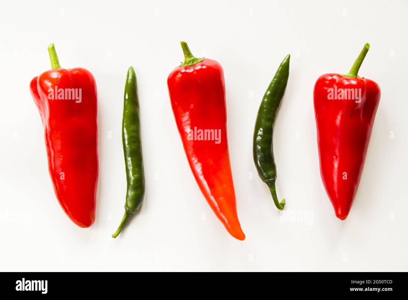 Top view of red bell pepper and green spicy pepper on a white ...