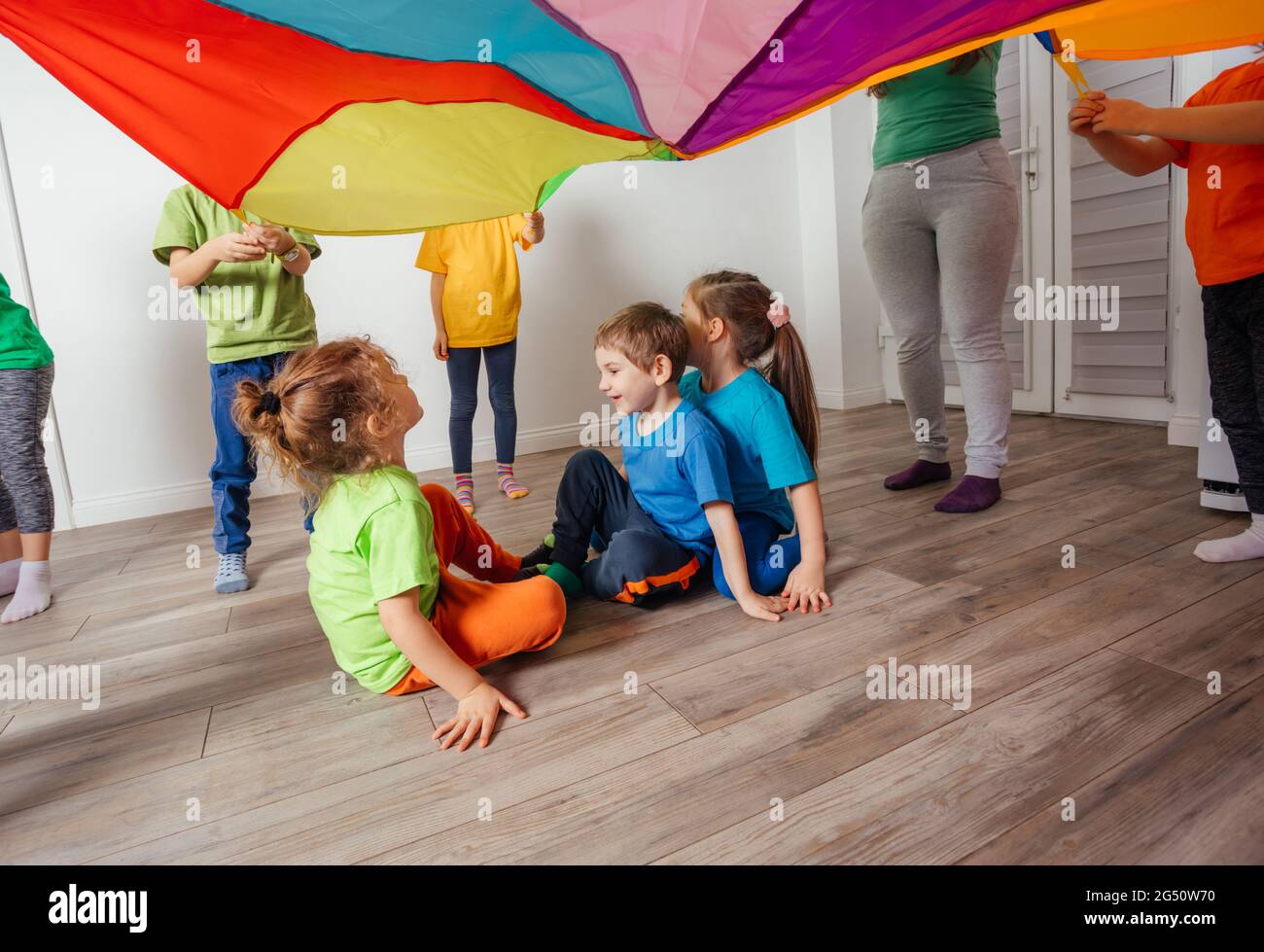 Games with colorful canopy, children sitting under parachute Stock ...