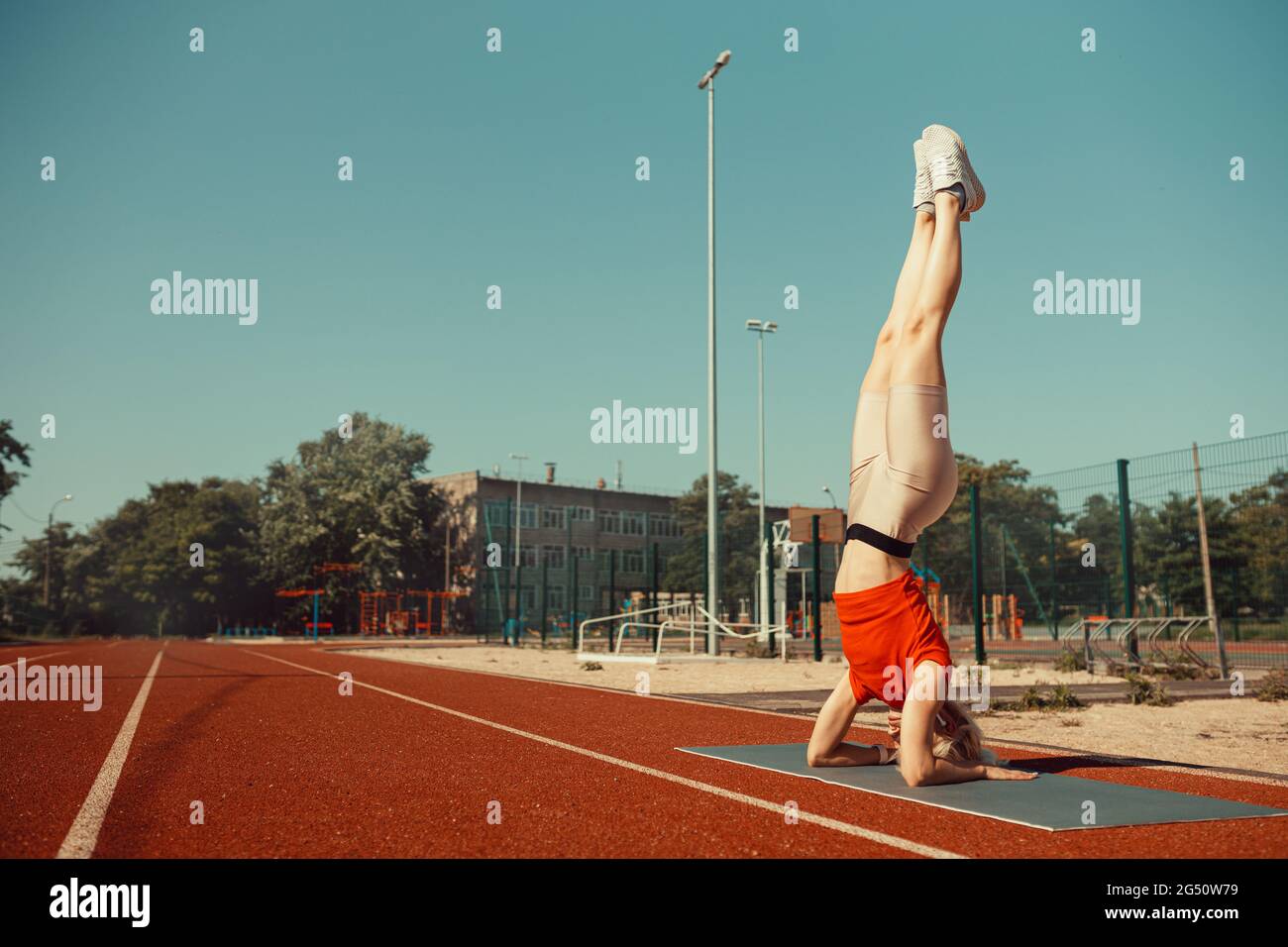 young blonde learns to balance in a headstand and handstand Stock Photo ...