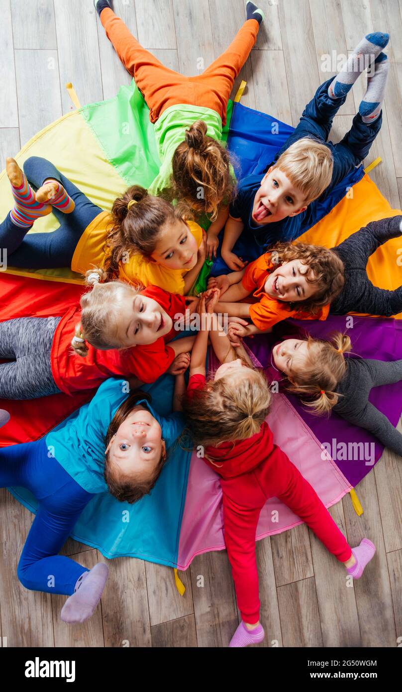Cheerful children playing team building games on a floor Stock Photo ...