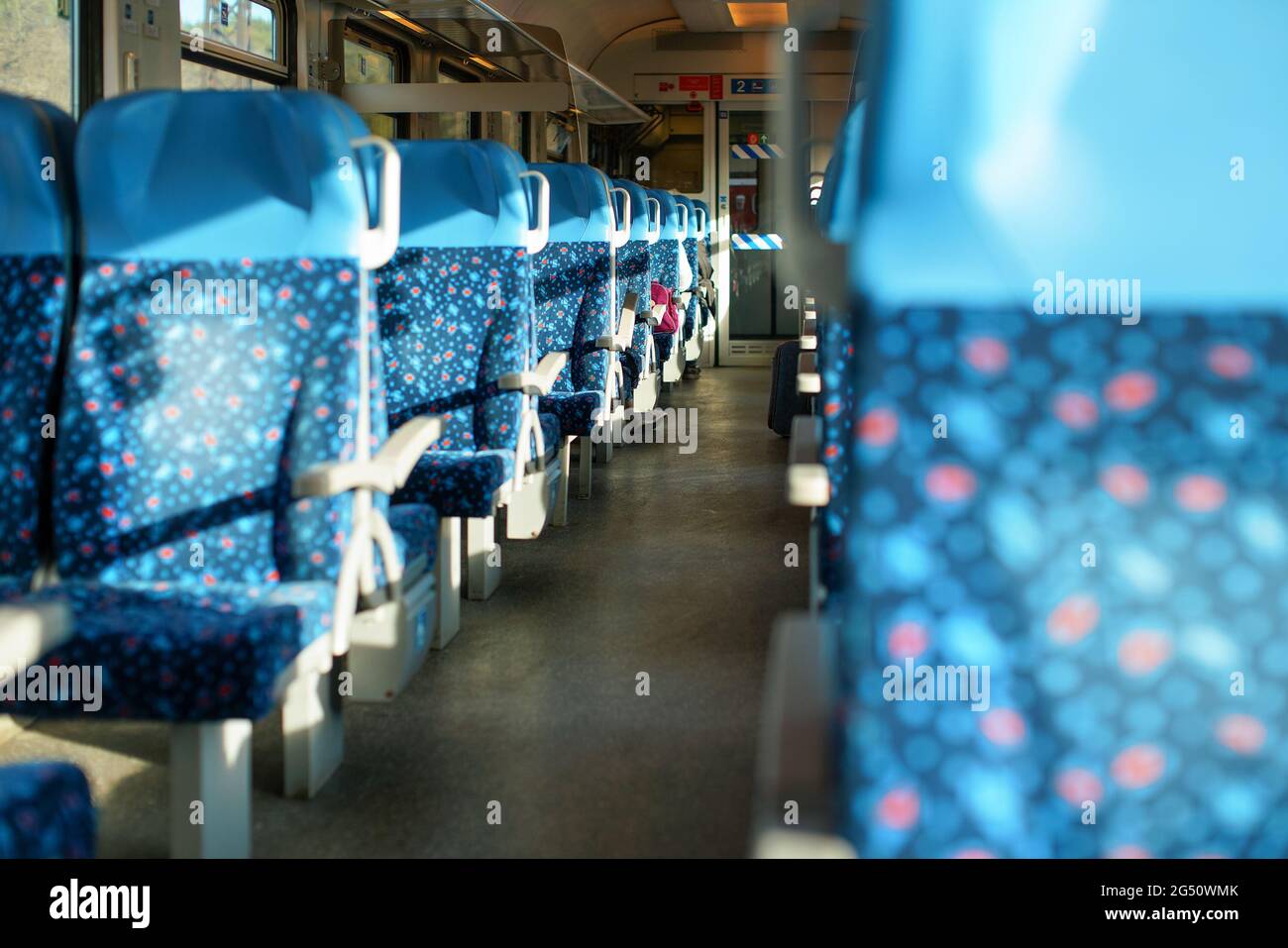 Sun shines on empty seats in train, abstract rail travel concept with ...