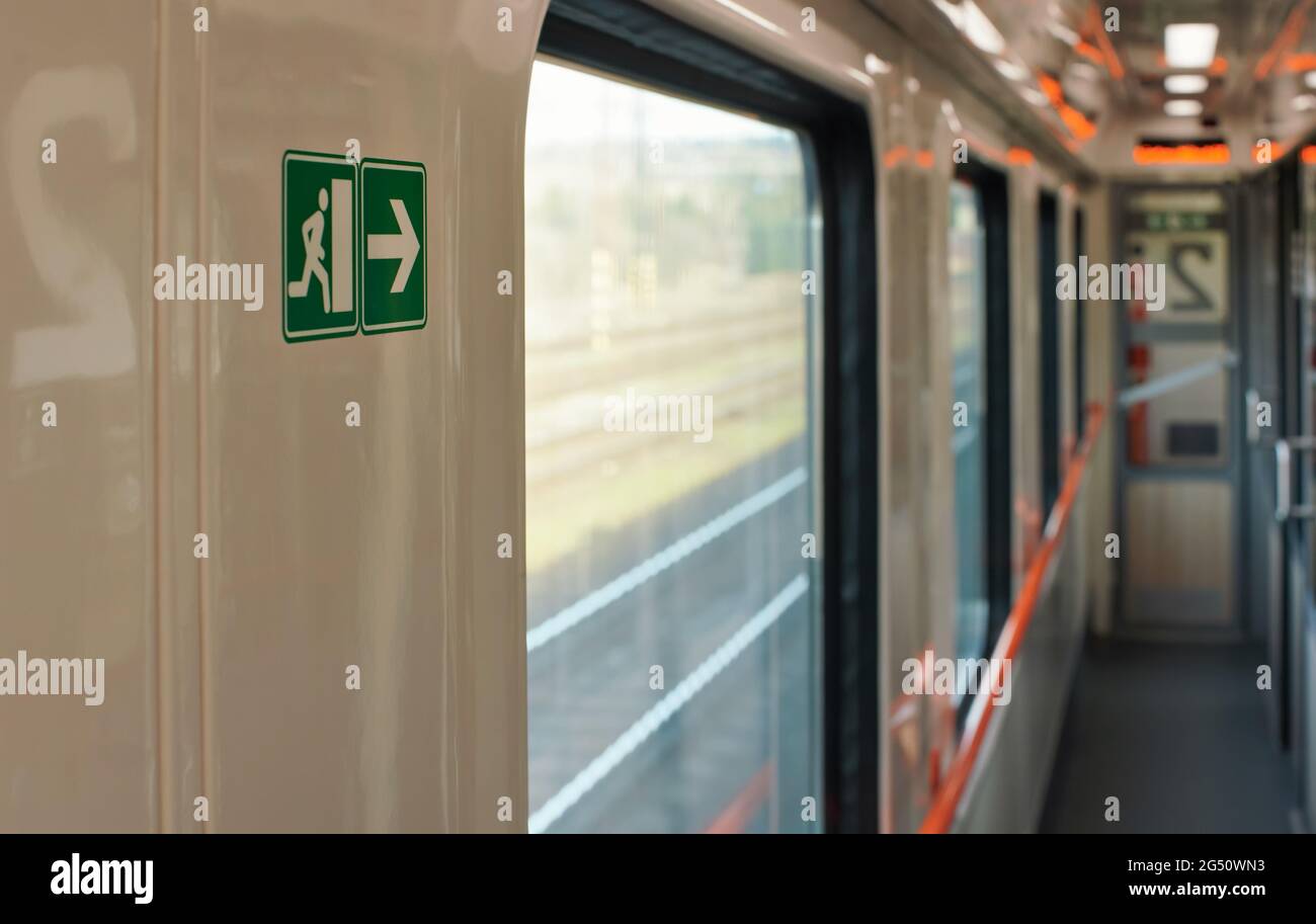 Aisle of train next to coupe cabins, blurred landscape behind window ...