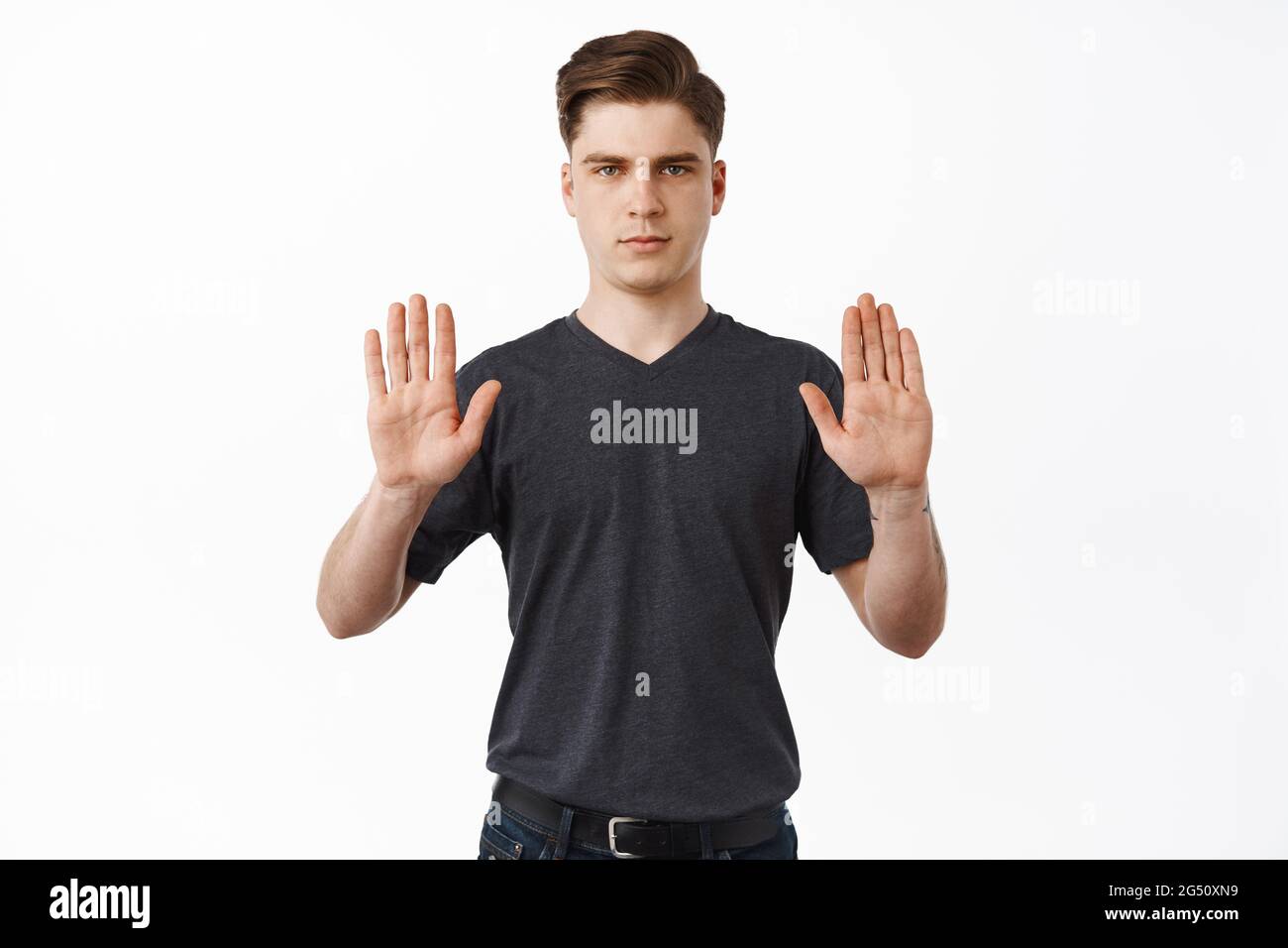 Stop it. Young caucasian man raising hands in block, decline gesture ...