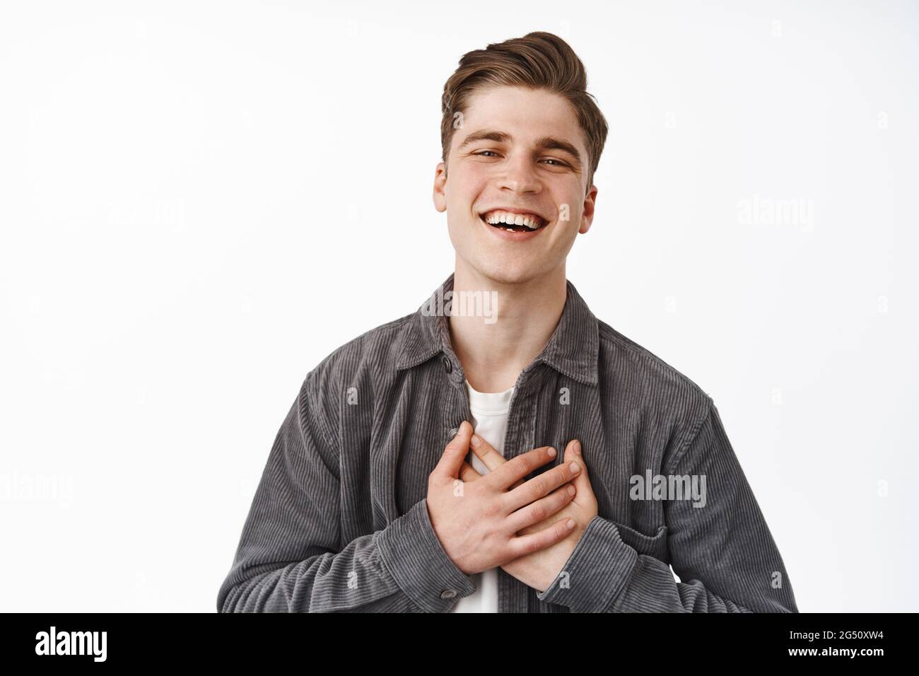 Close up of modern happy guy, young man laughing flattered, hold hands ...