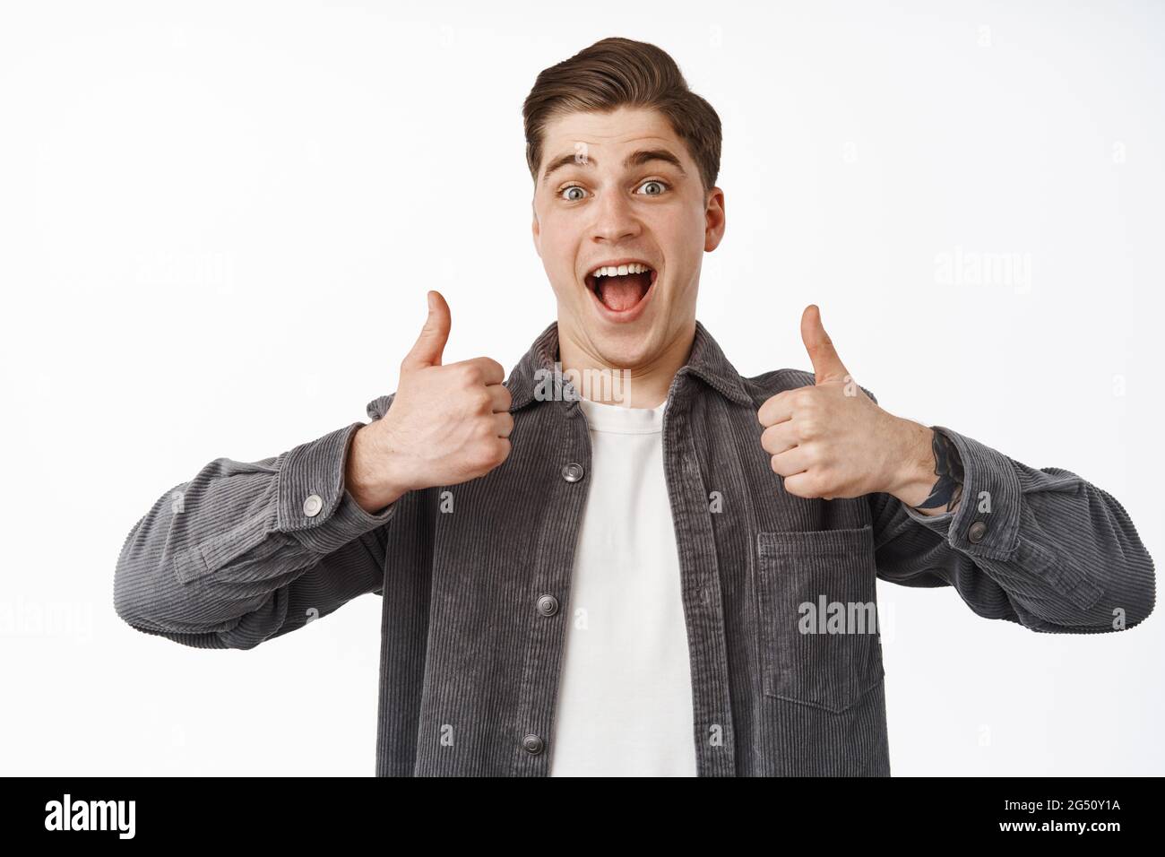 Close up portrait of excited handsome man, say yes and show thumbs up ...