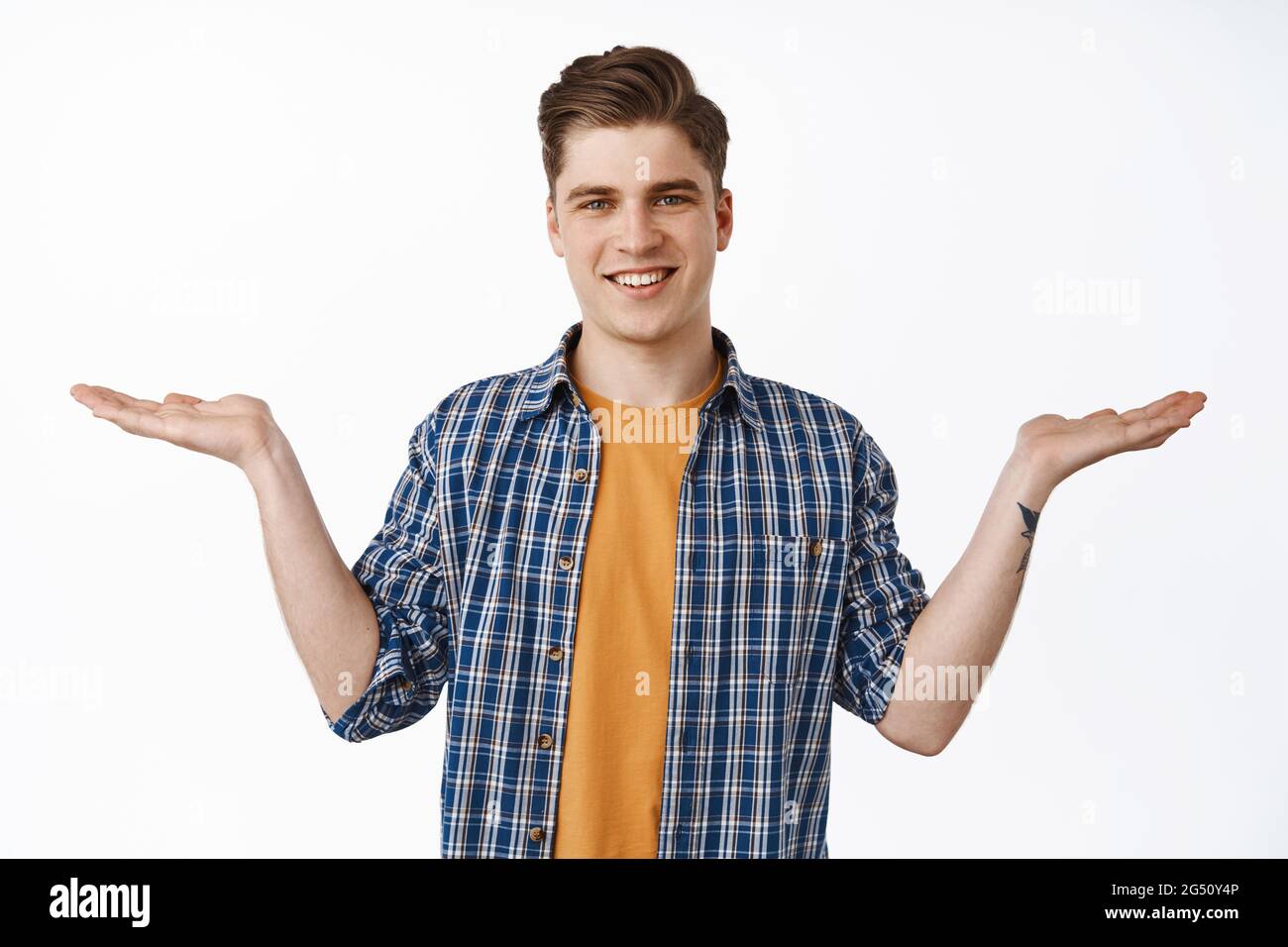 Display product. Smiling young man advertising, holding in open hands ...