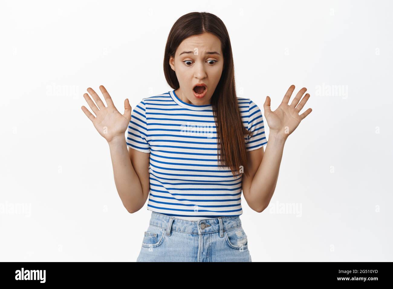 Shocked young woman scream, gasp and stare startled down at smth ...