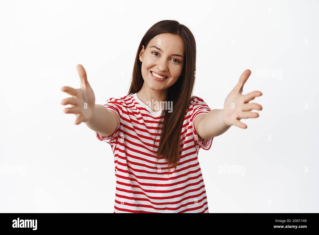 Portrait of beautiful 20s girl reaching for hug, spread hands sideways ...