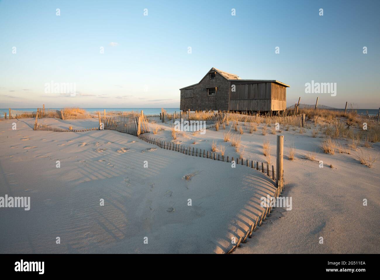 Abandoned beach shack on the Atlantic Ocean coast with sand dunes and a ...