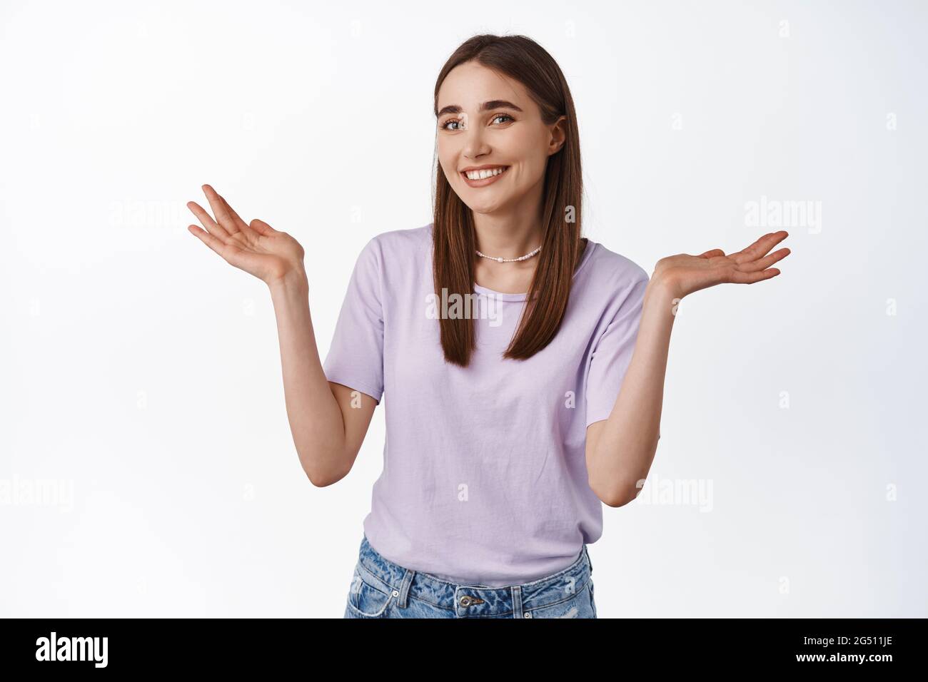 Oops sorry silly mistake. Smiling girl shrugging shoulders with awkward ...