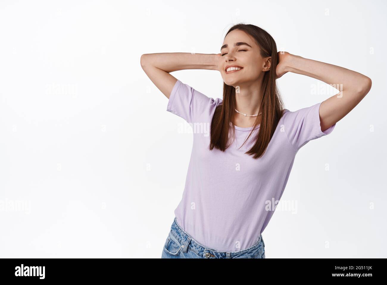 Free and relaxed young woman relaxing, close eyes and smile, holds ...