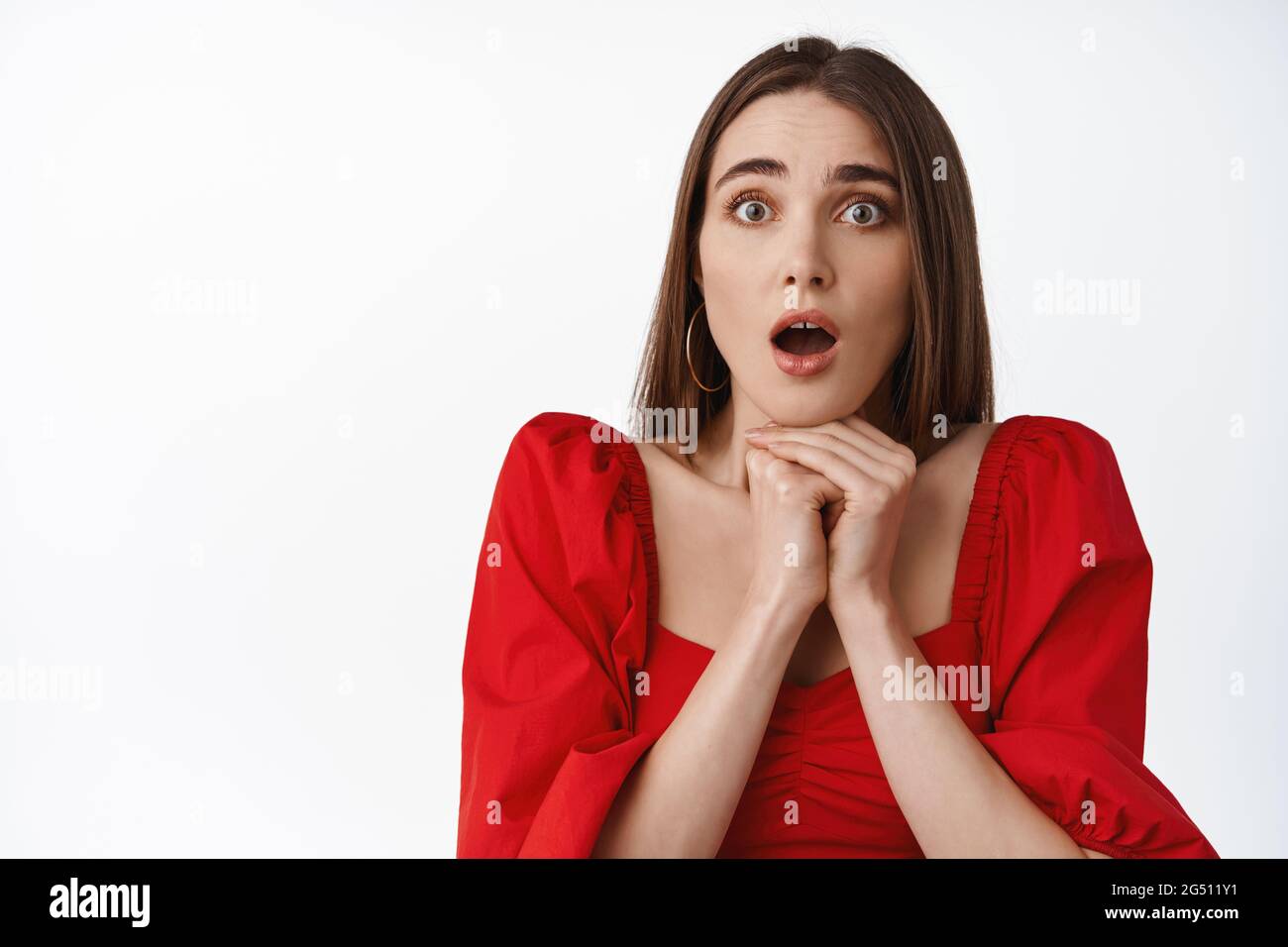 Shocked young woman looks startled and amazed, speechless staring at ...