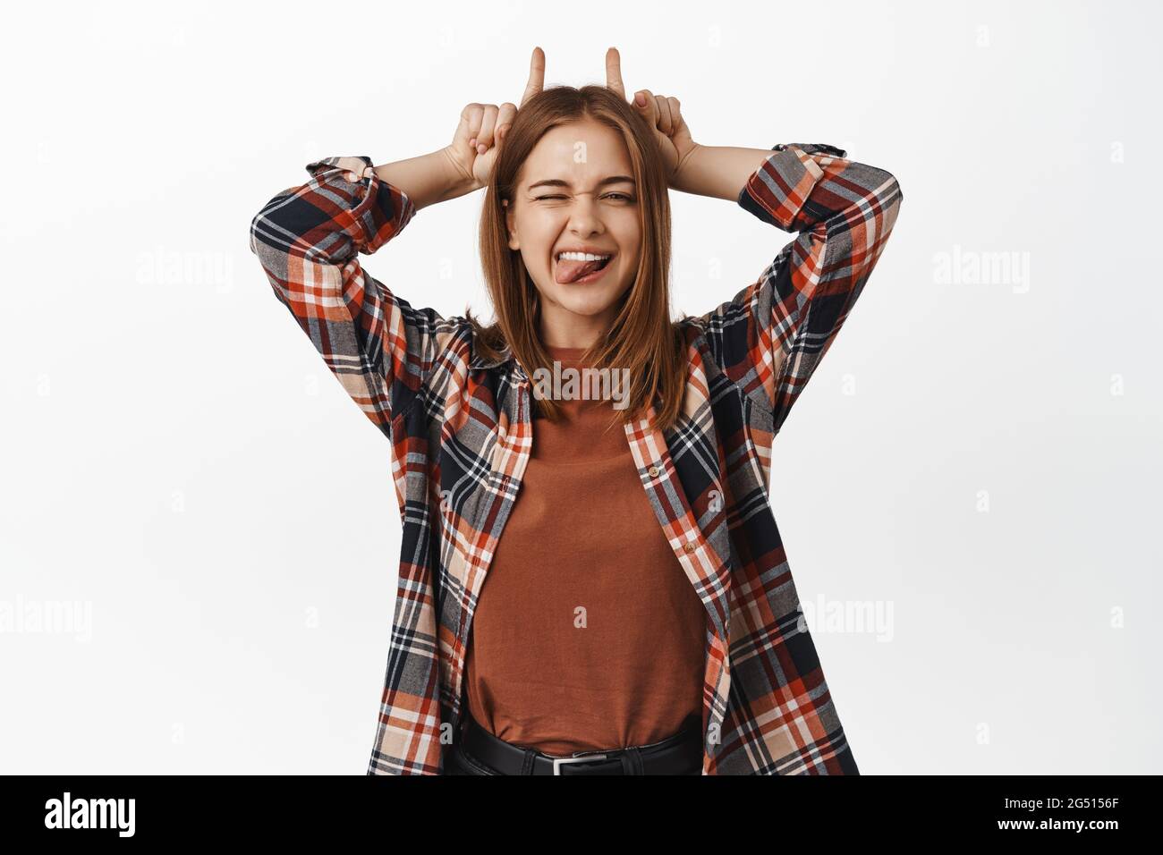 Image of happy young woman shows bull horns, tongue and wink, joyful ...