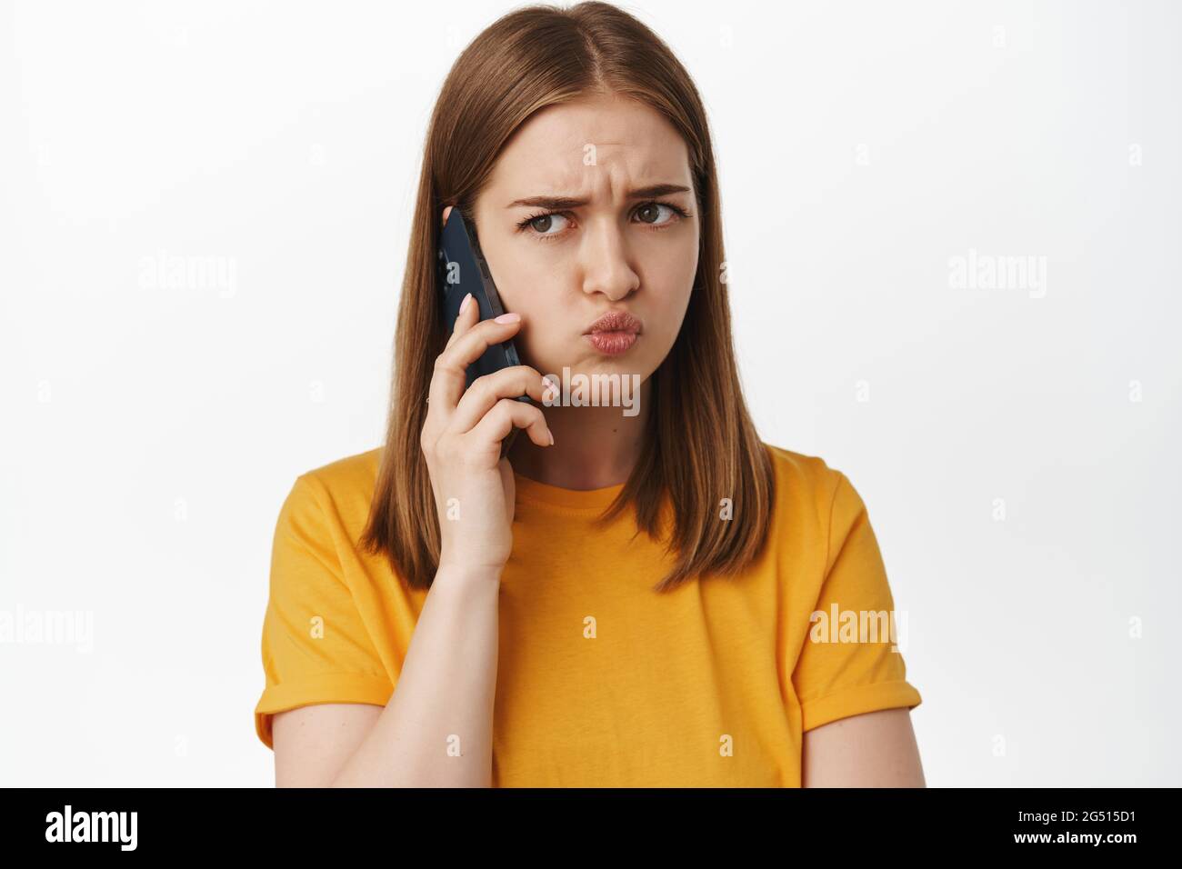 Close up of upset whining girl talking on mobile phone and grimacing ...