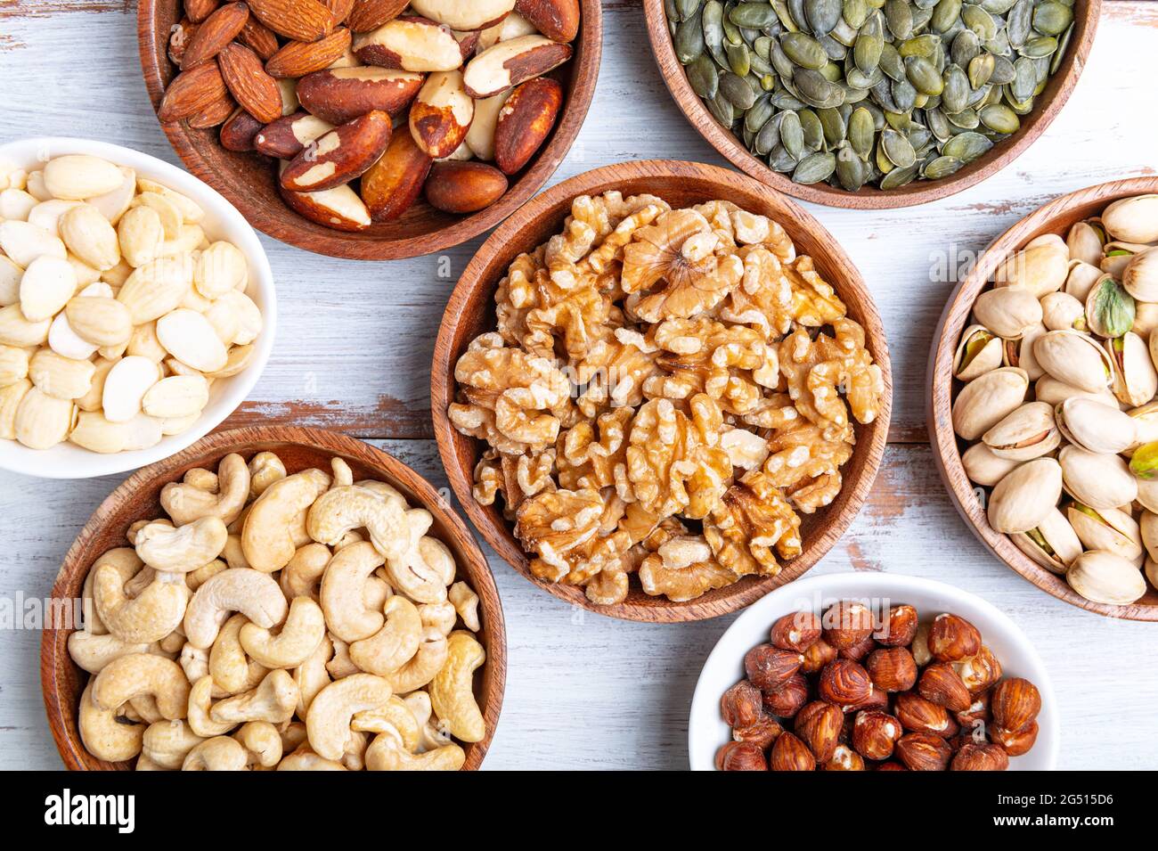 Different kind of nuts in wooden bowls Stock Photo - Alamy