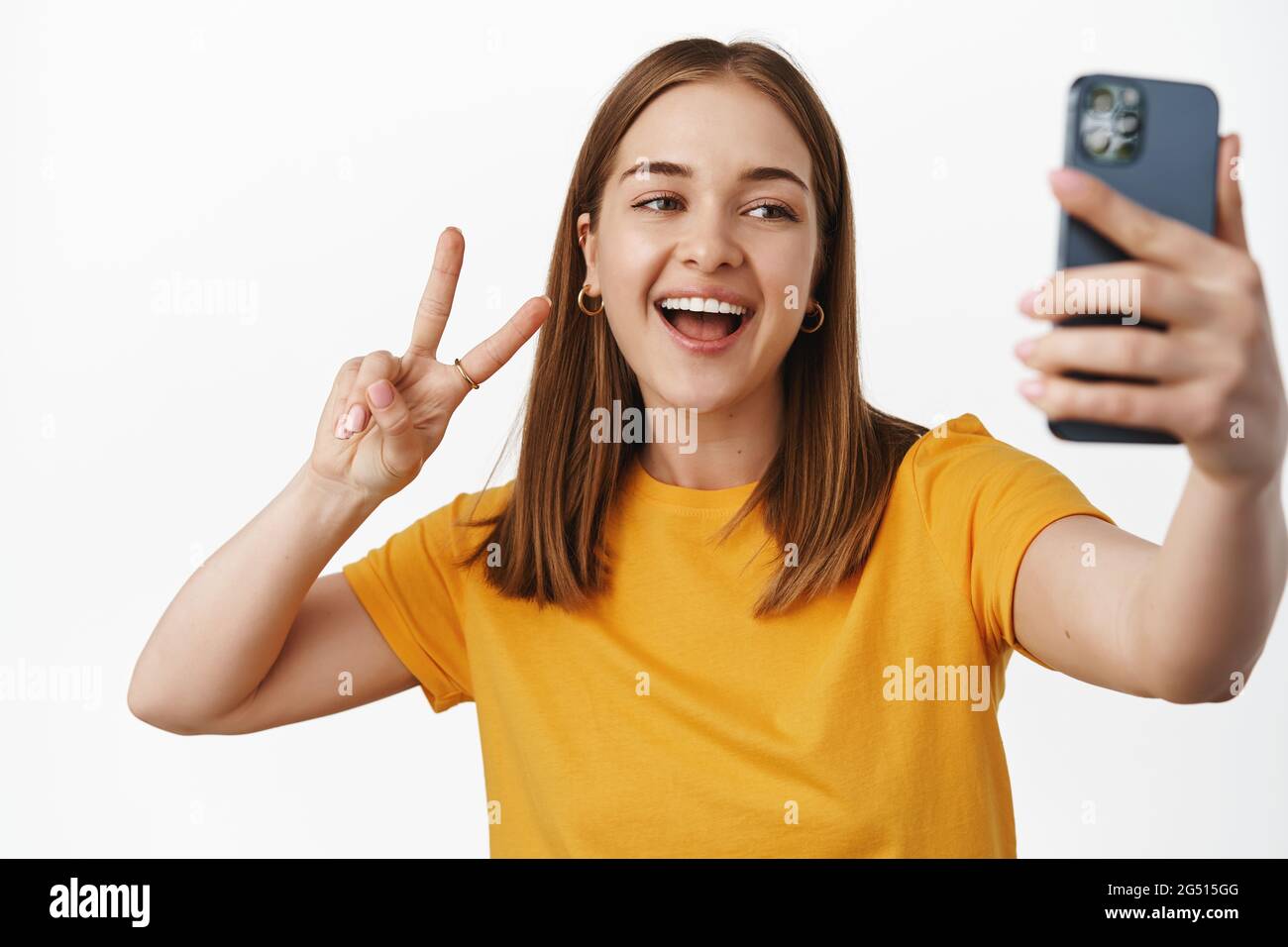 Happy Girl Taking Selfie With Peace Sign On Smartphone Posing For