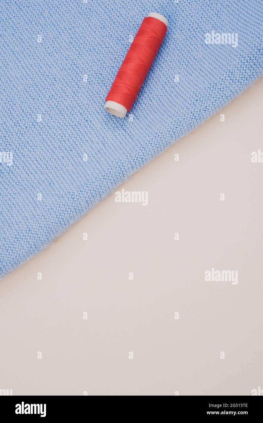 Closeup of a red sewing thread on the fabric on the brown surface Stock ...