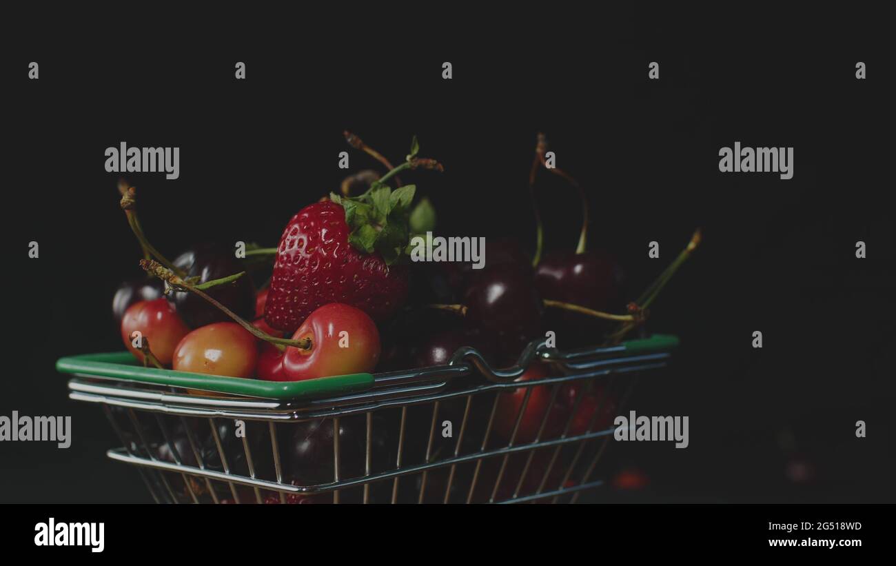 Red fresh strawberries and cherries in a little trolley from a super ...