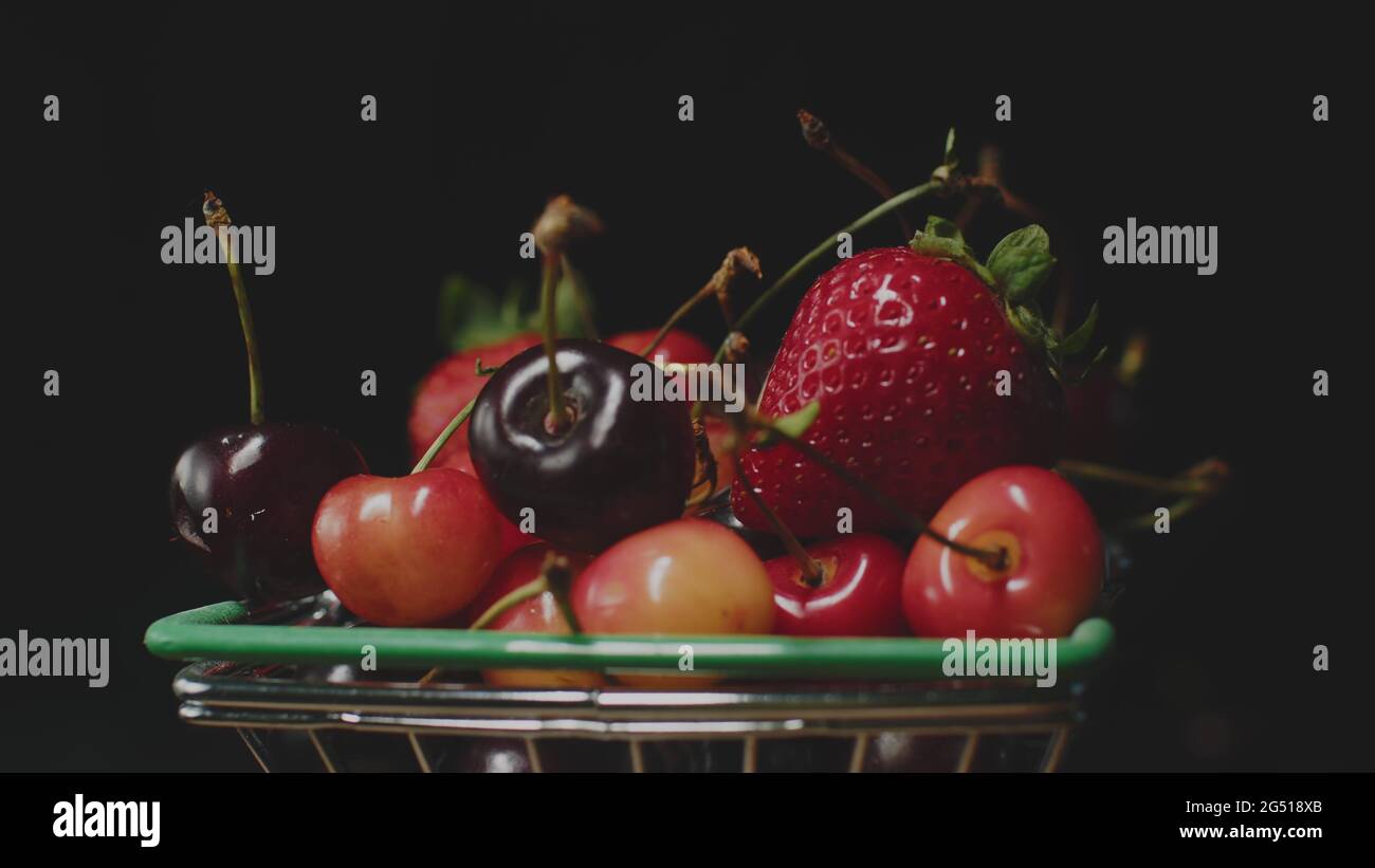 Red fresh strawberries and cherries in a little trolley from a super ...