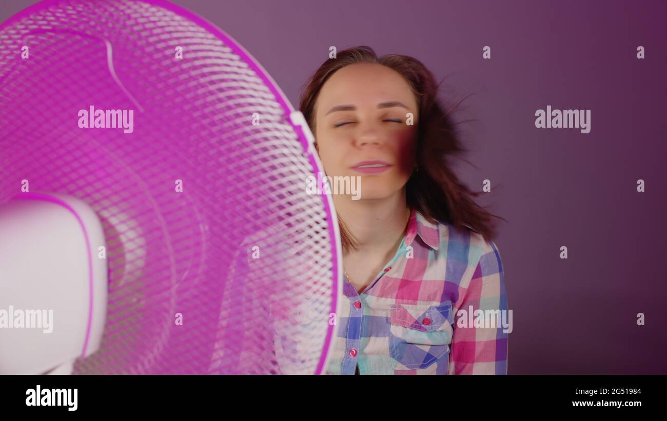 Close up of young woman waves her head, sitting on chair in front of ...