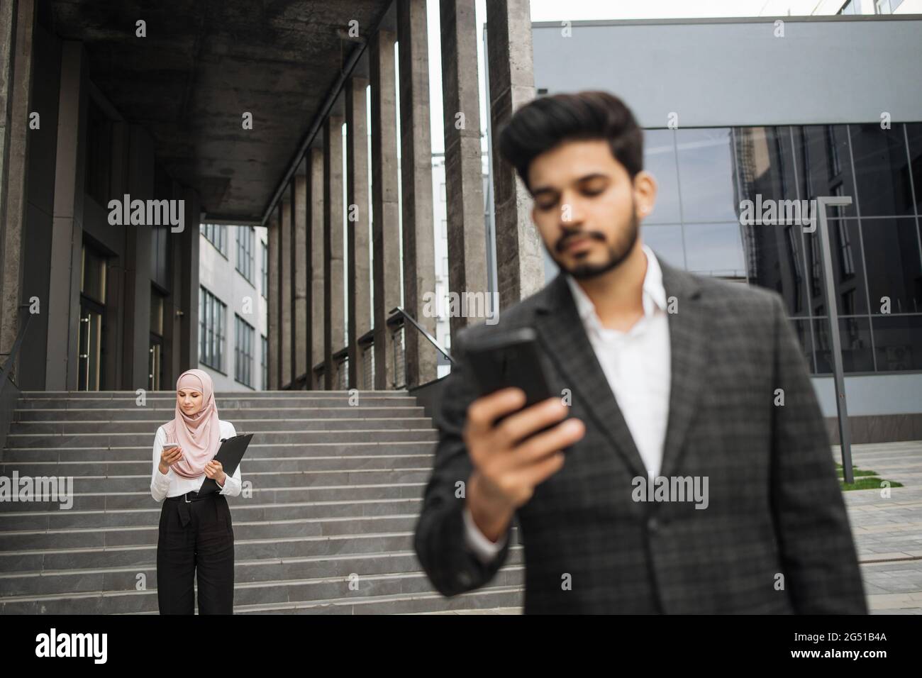 Successful arabian business partners using personal cell phones near ...