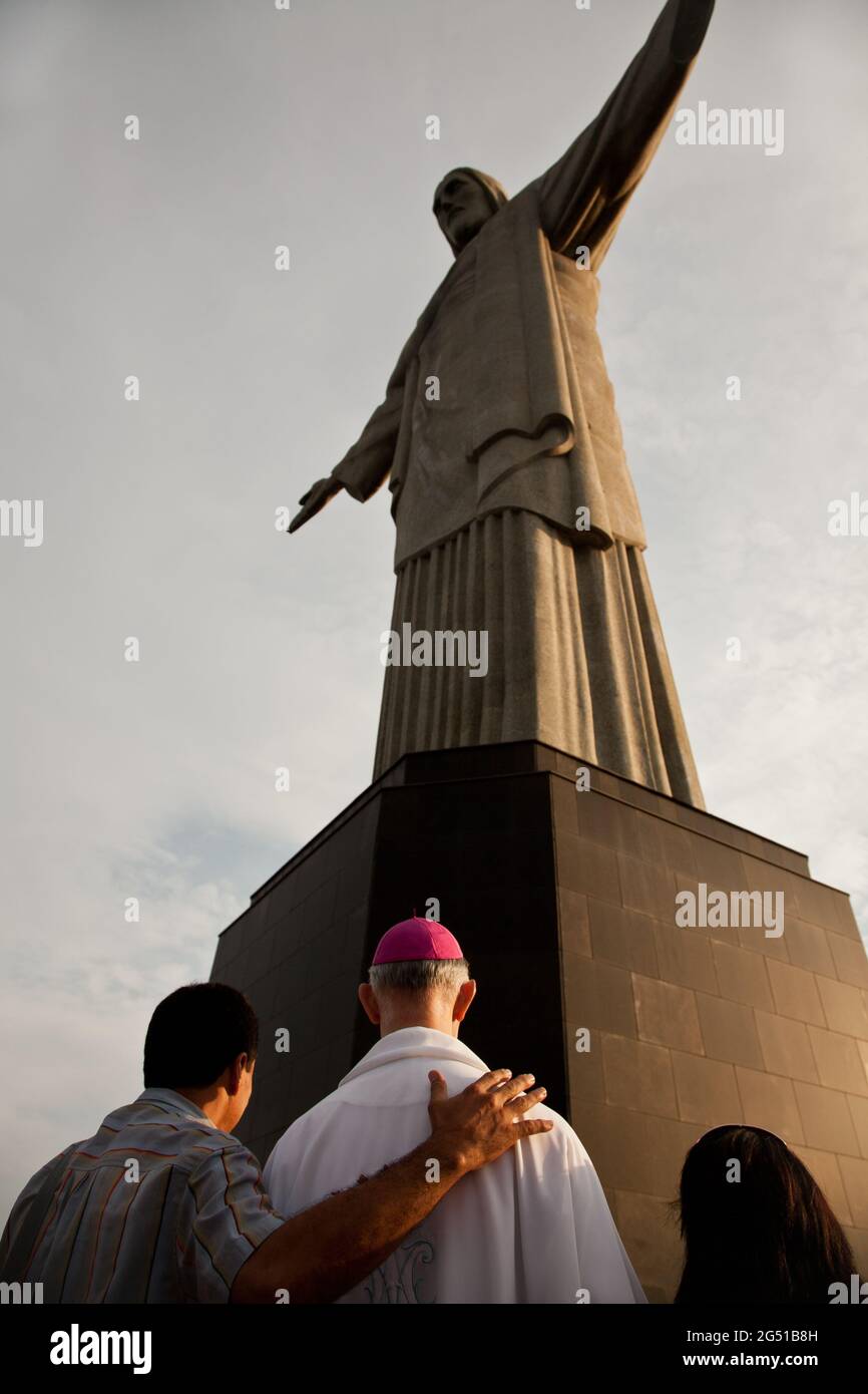 A man holding a bishop, under the statue of Christ the Redeemer, at ...